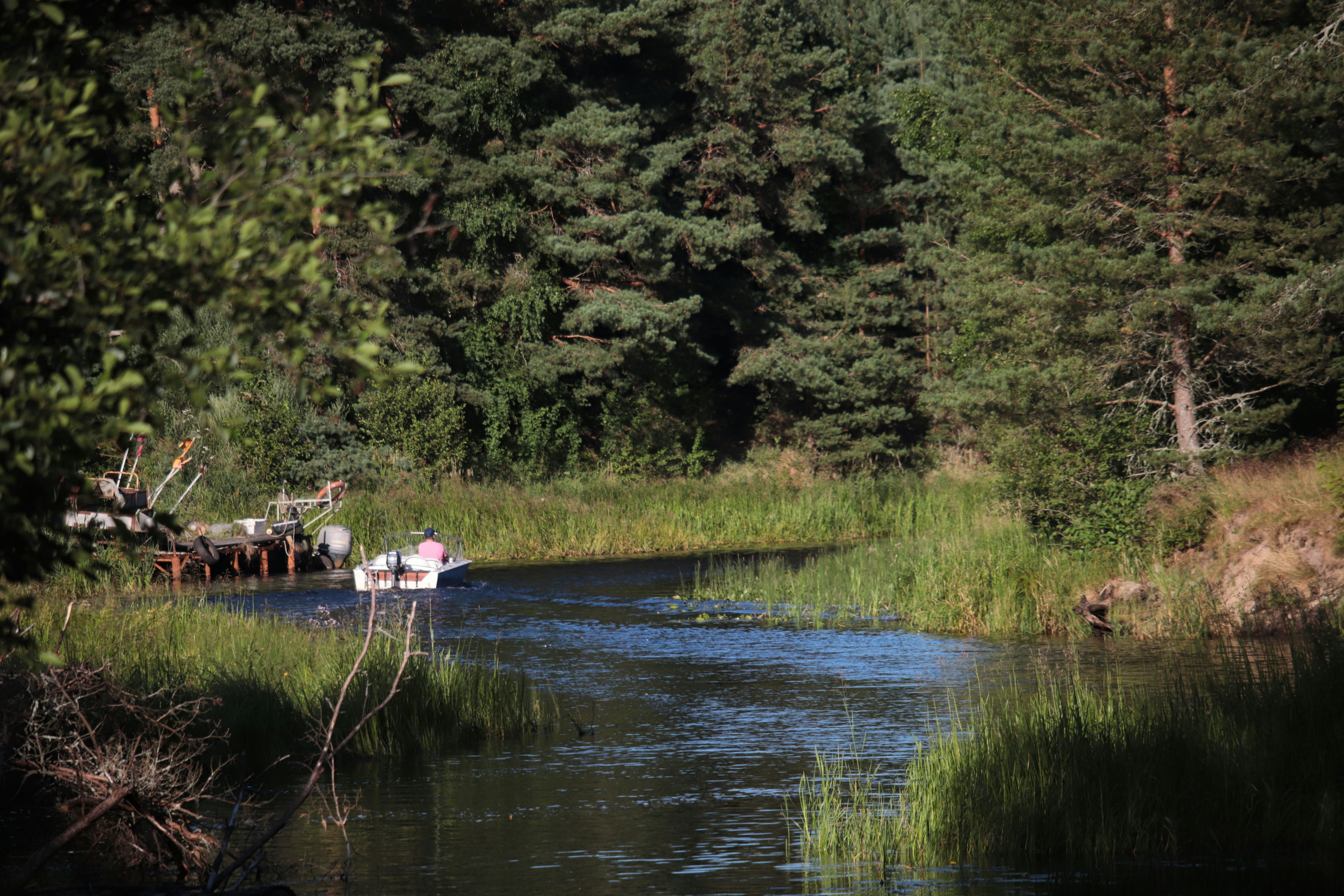 A Quiet Boat Resting Along a Shaded River Bend