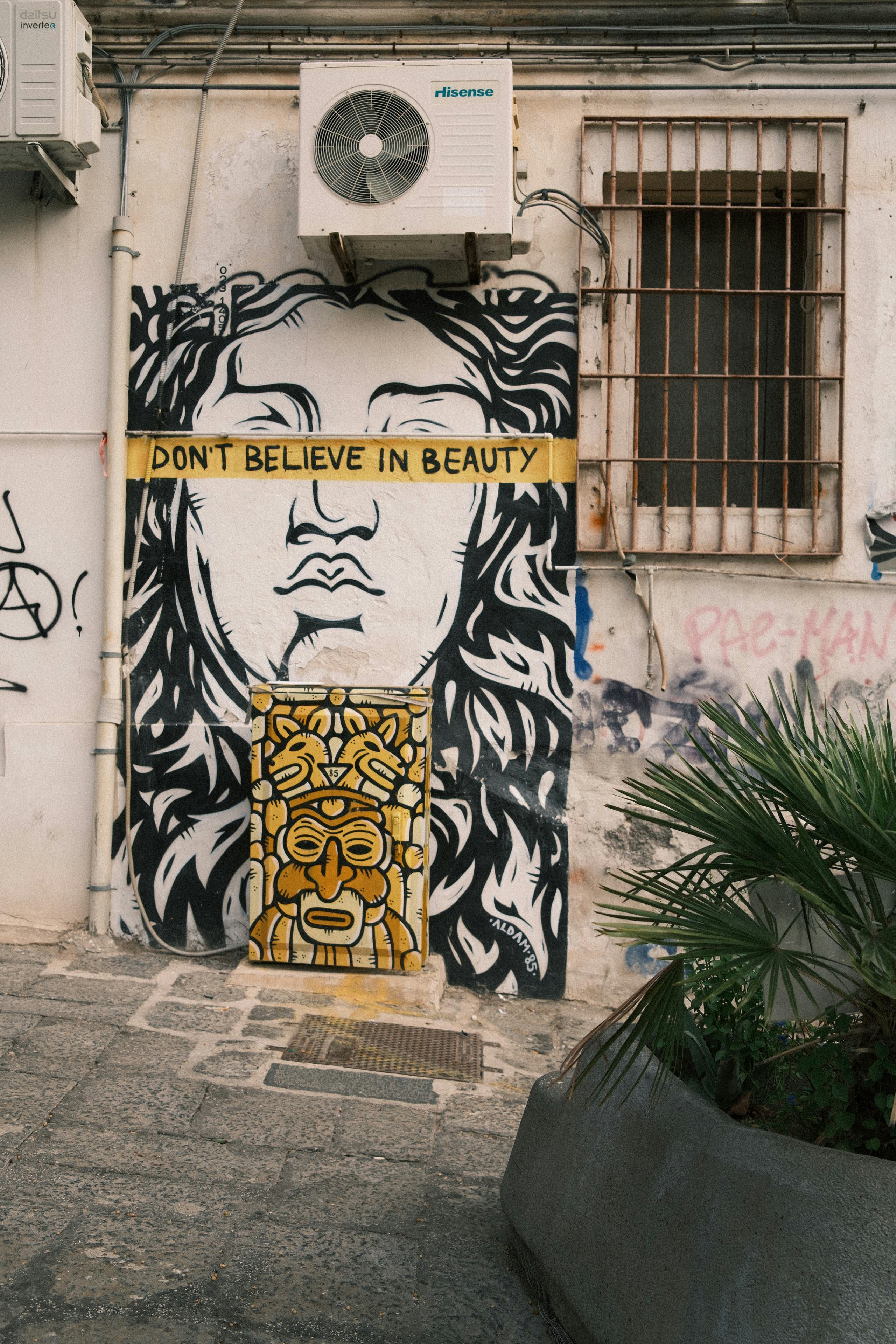 Face in the Wall: Don't Believe in Beauty Ribbon Across the Mural