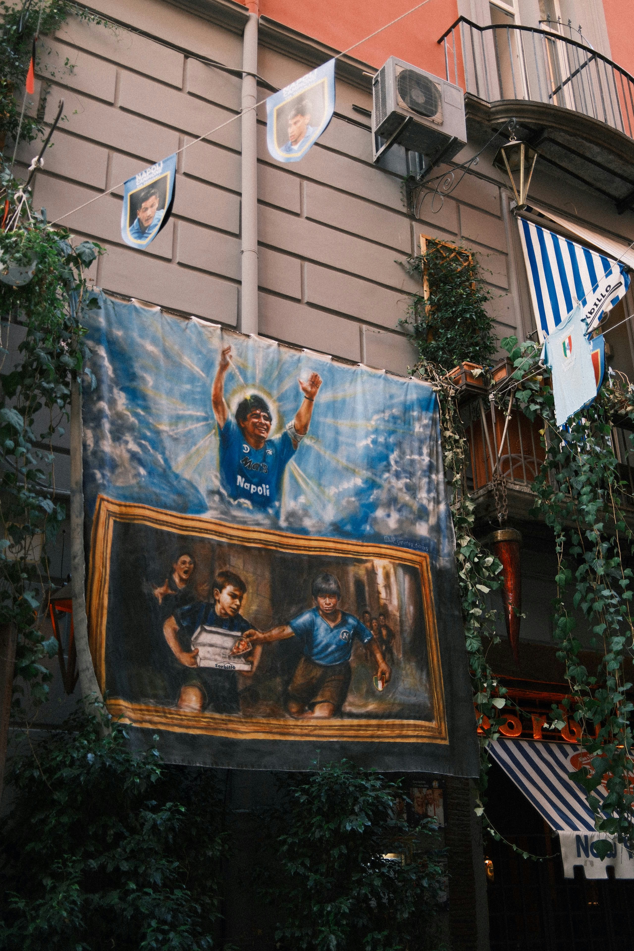 Colorful Street Banner Portraits Adorning a Neoclassical Facade