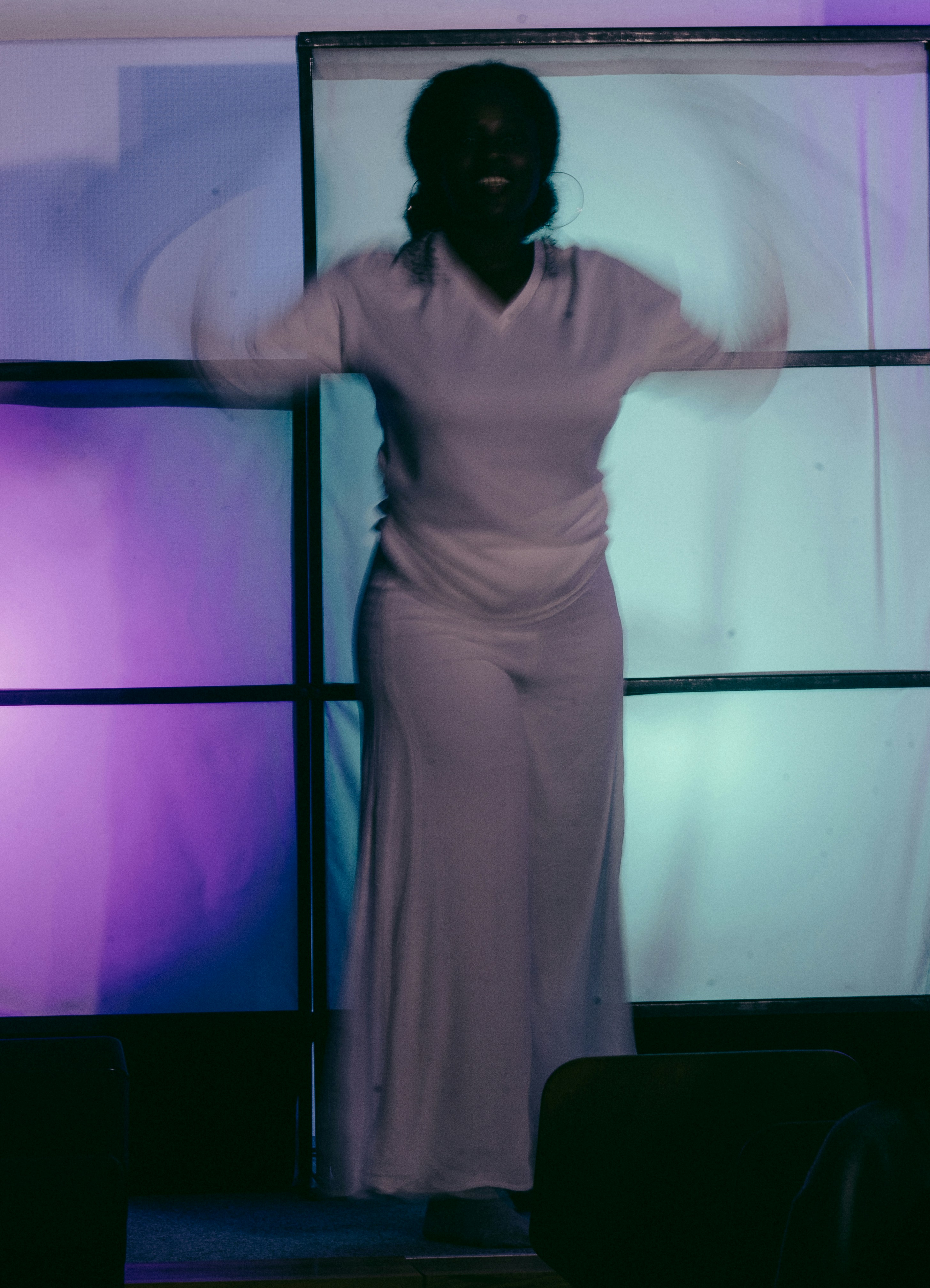 Silhouette in Color: A Moving Presence on Stage Backdrop