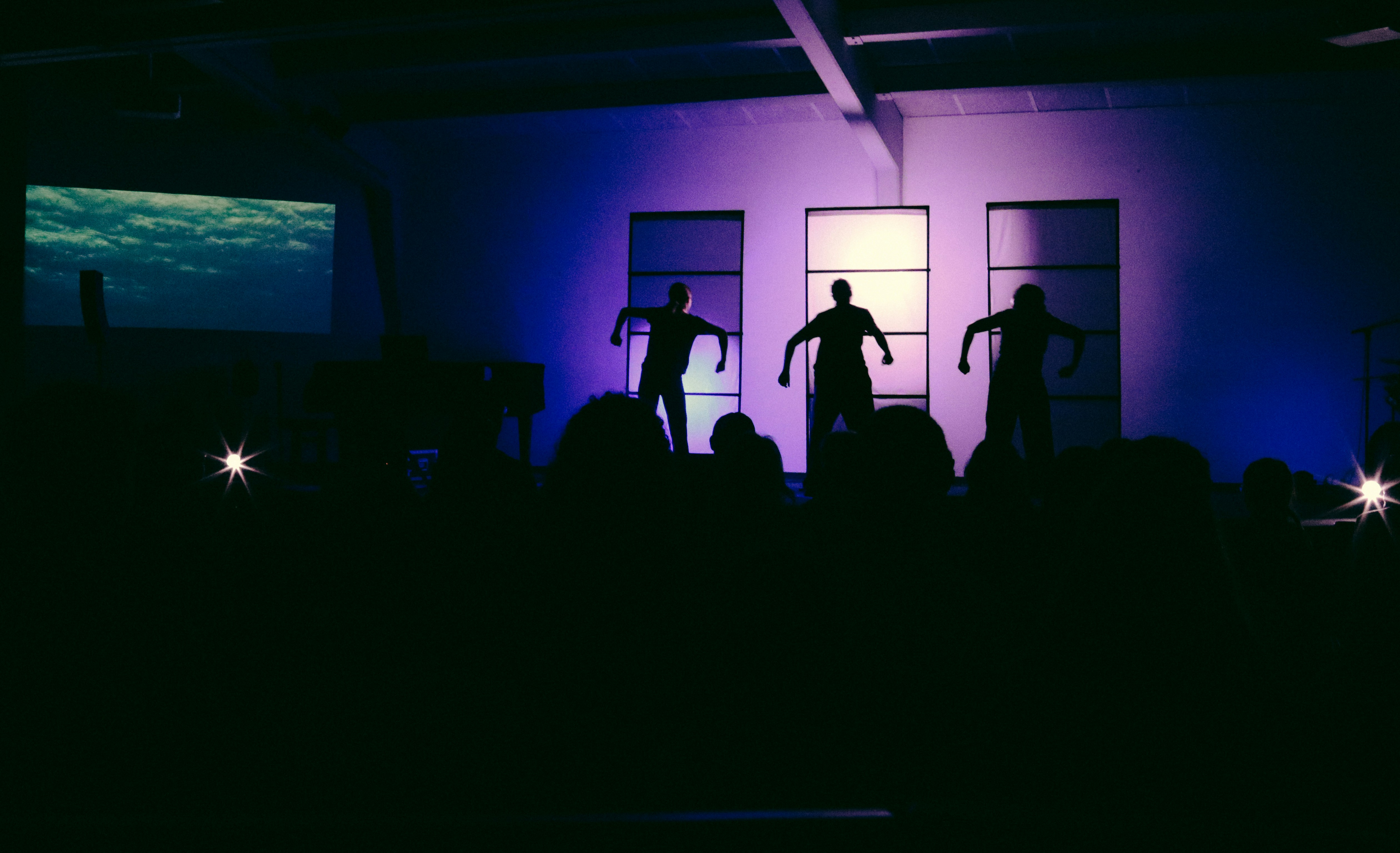 Silhouetted Dancers Under Neon Backlight