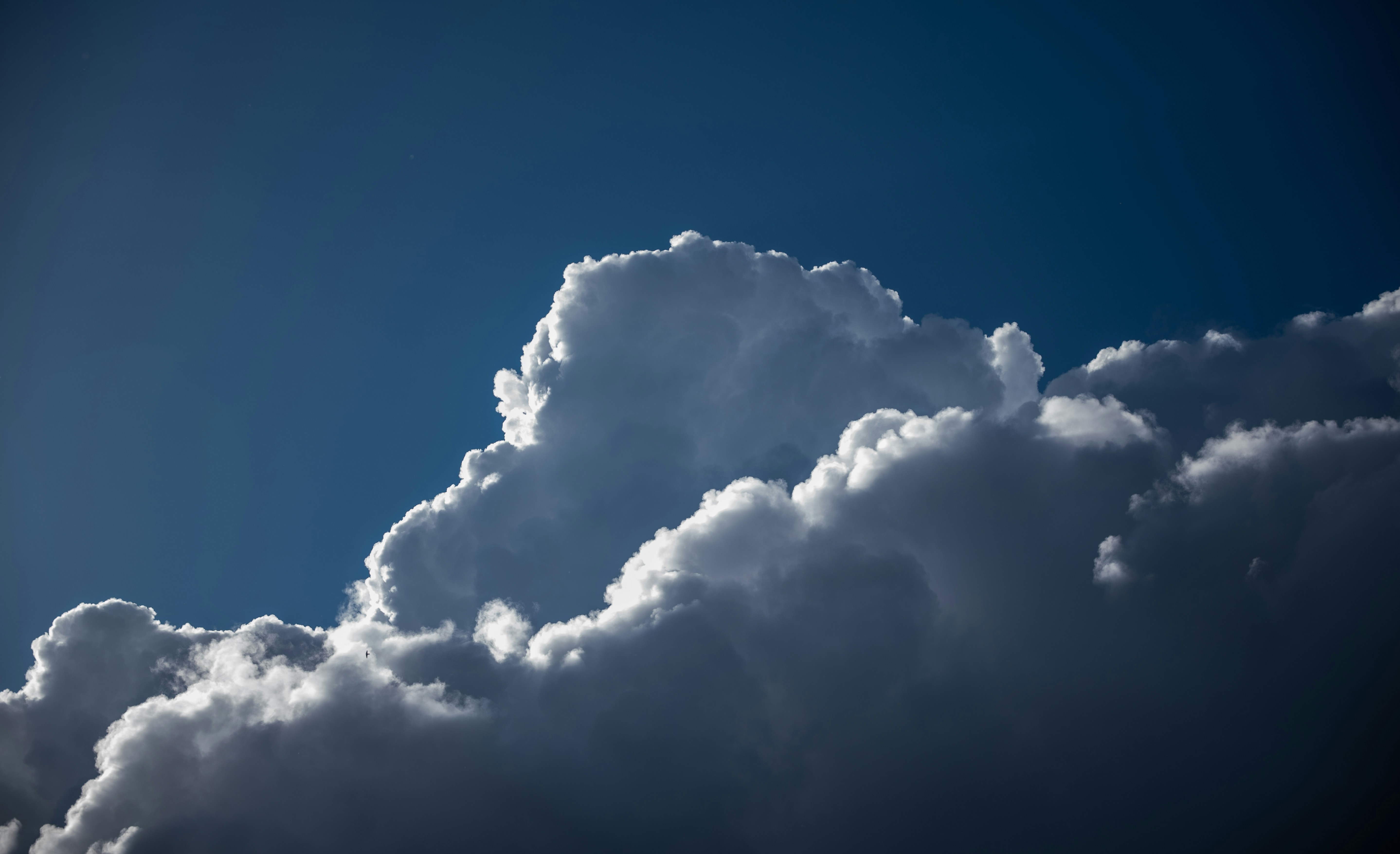 Edge of the Sky: A Majestic Cloud Crown Over Dark Blue Tone