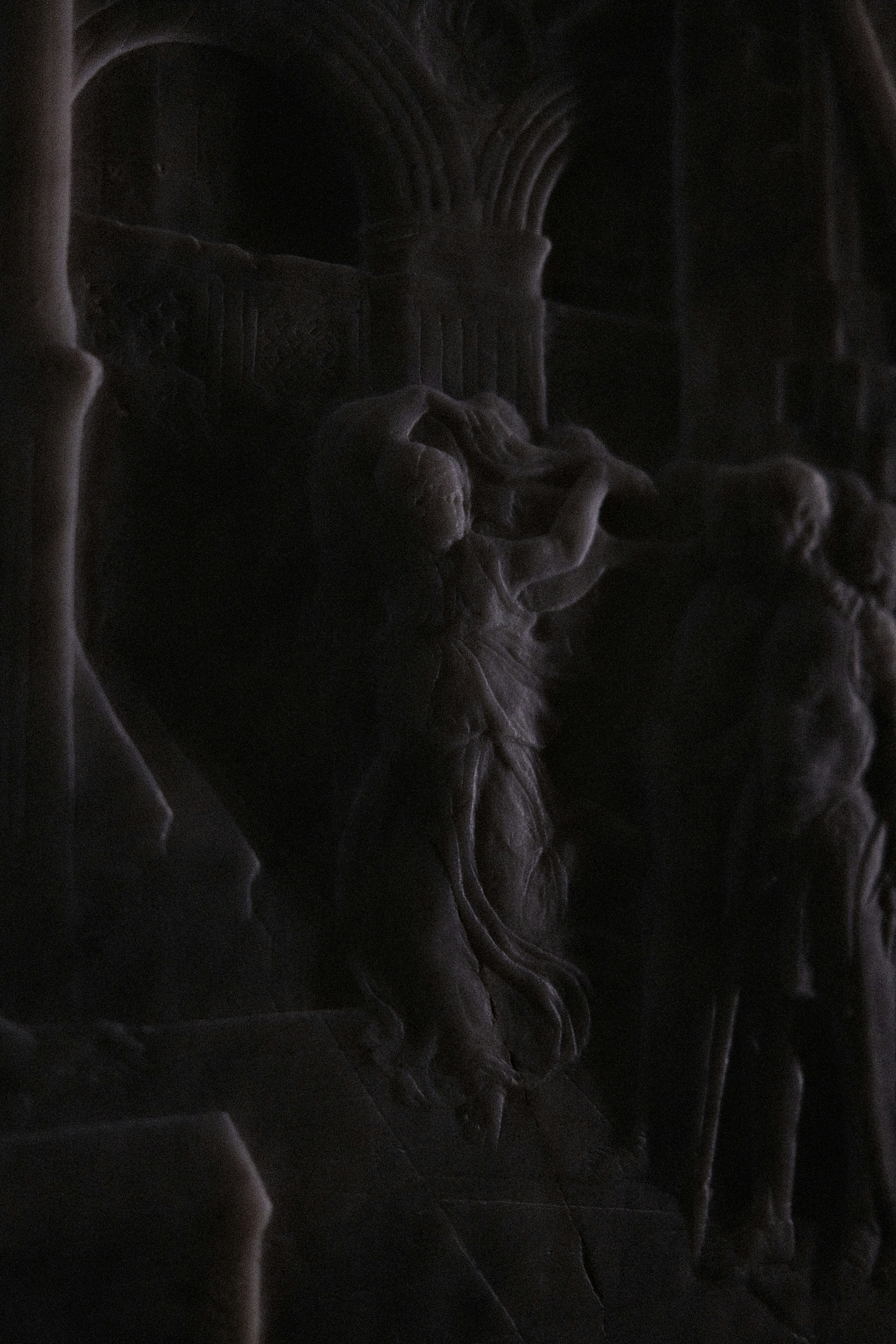 Low-Light Stone Carving in Shadowed Gallery