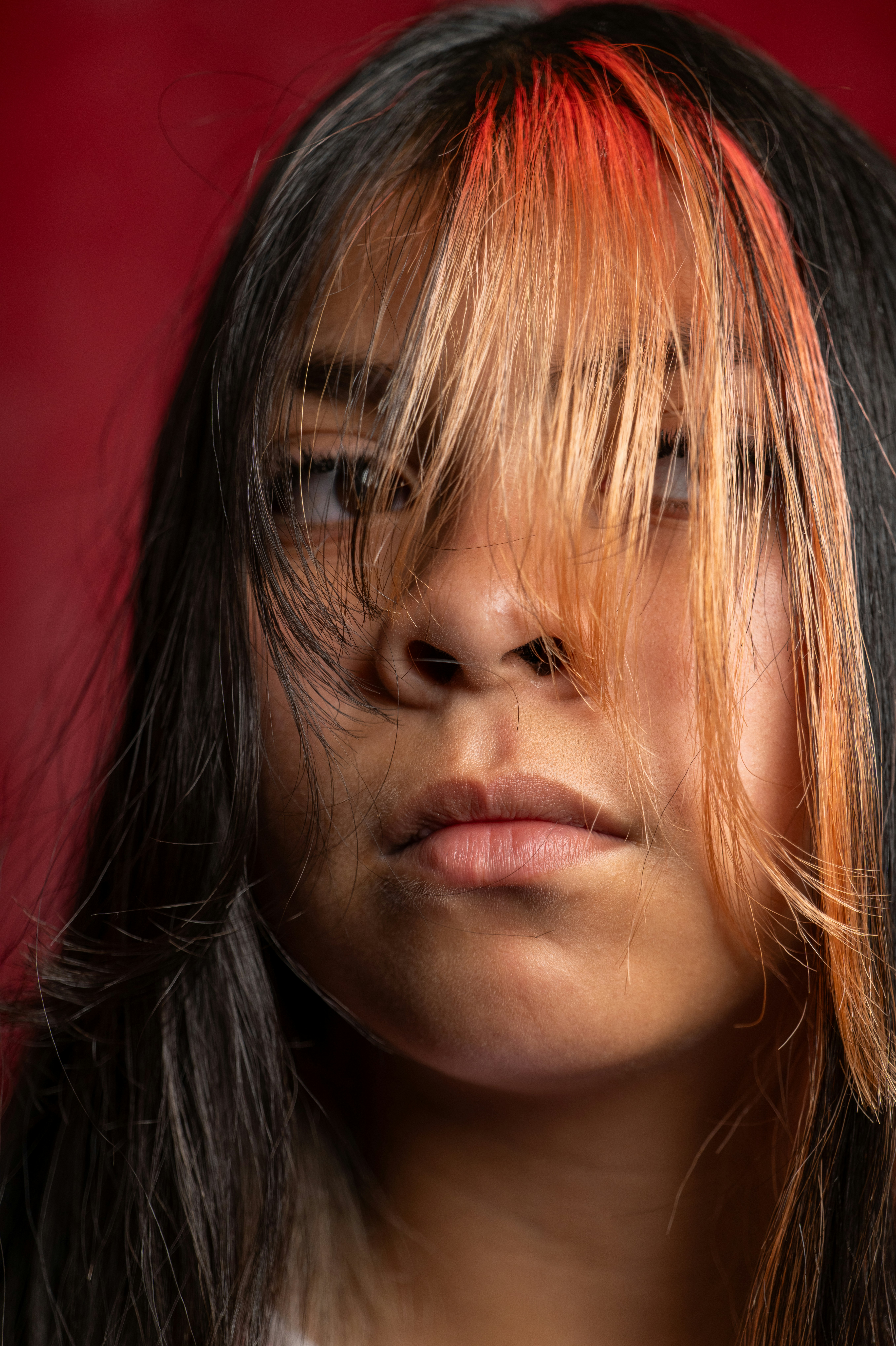 Tangled Hair, Fierce Gaze: A Close-Up Portrait with Fiery Fringe