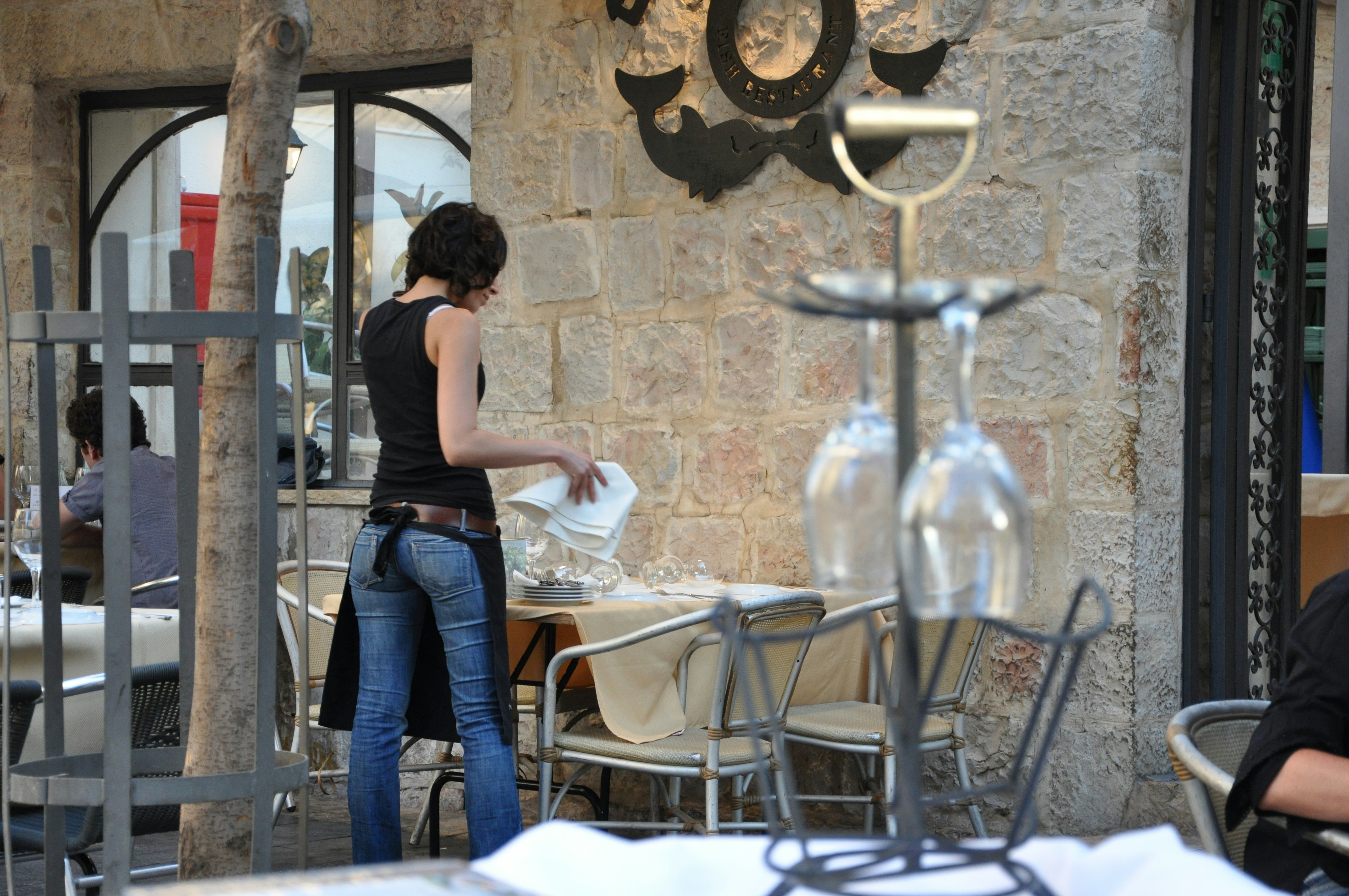 Cafe Scene: Barista in Focus at a Stone-Walled Patio