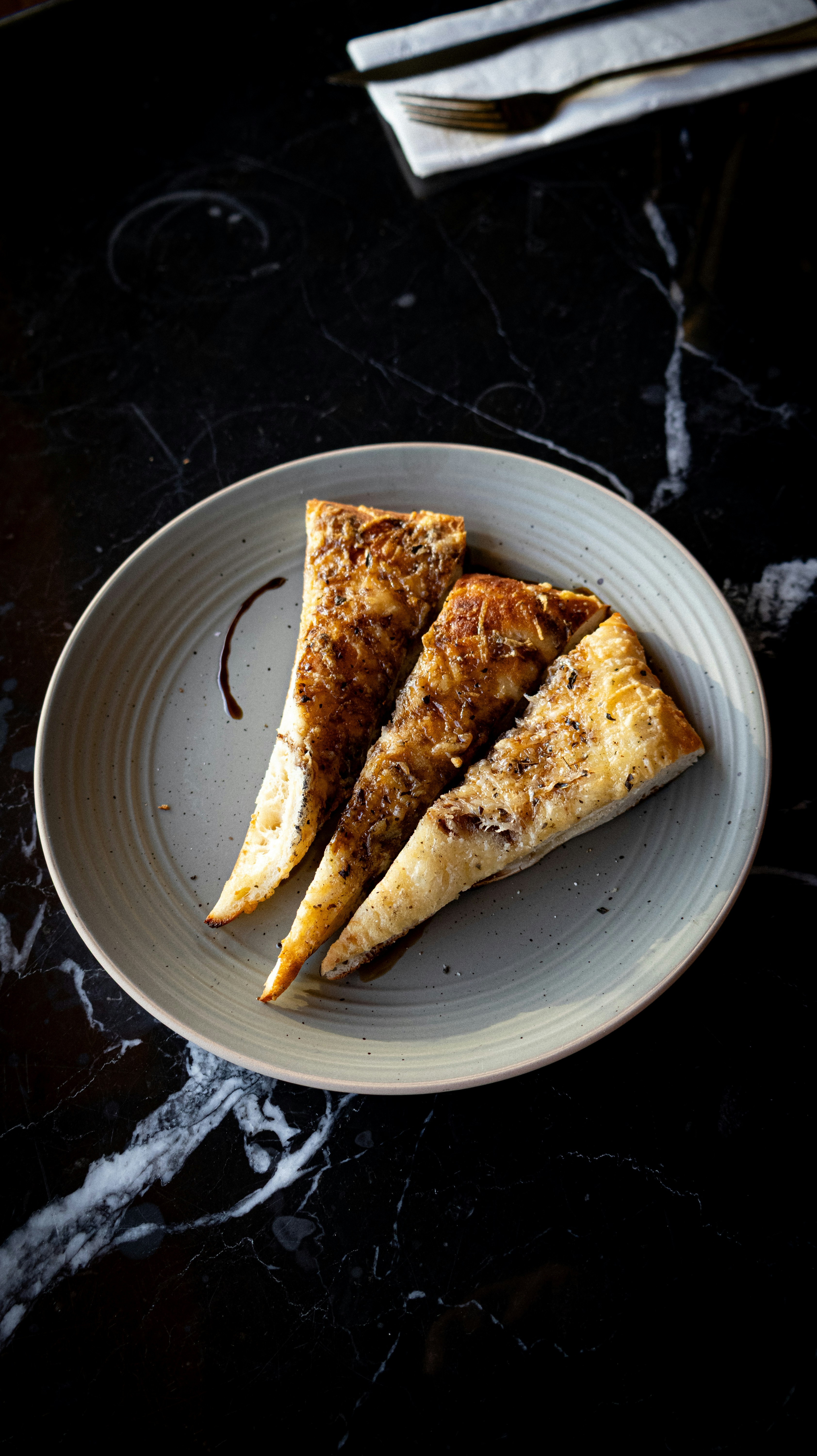 Angular slices of dessert: a caramelized trio on a cool gray plate