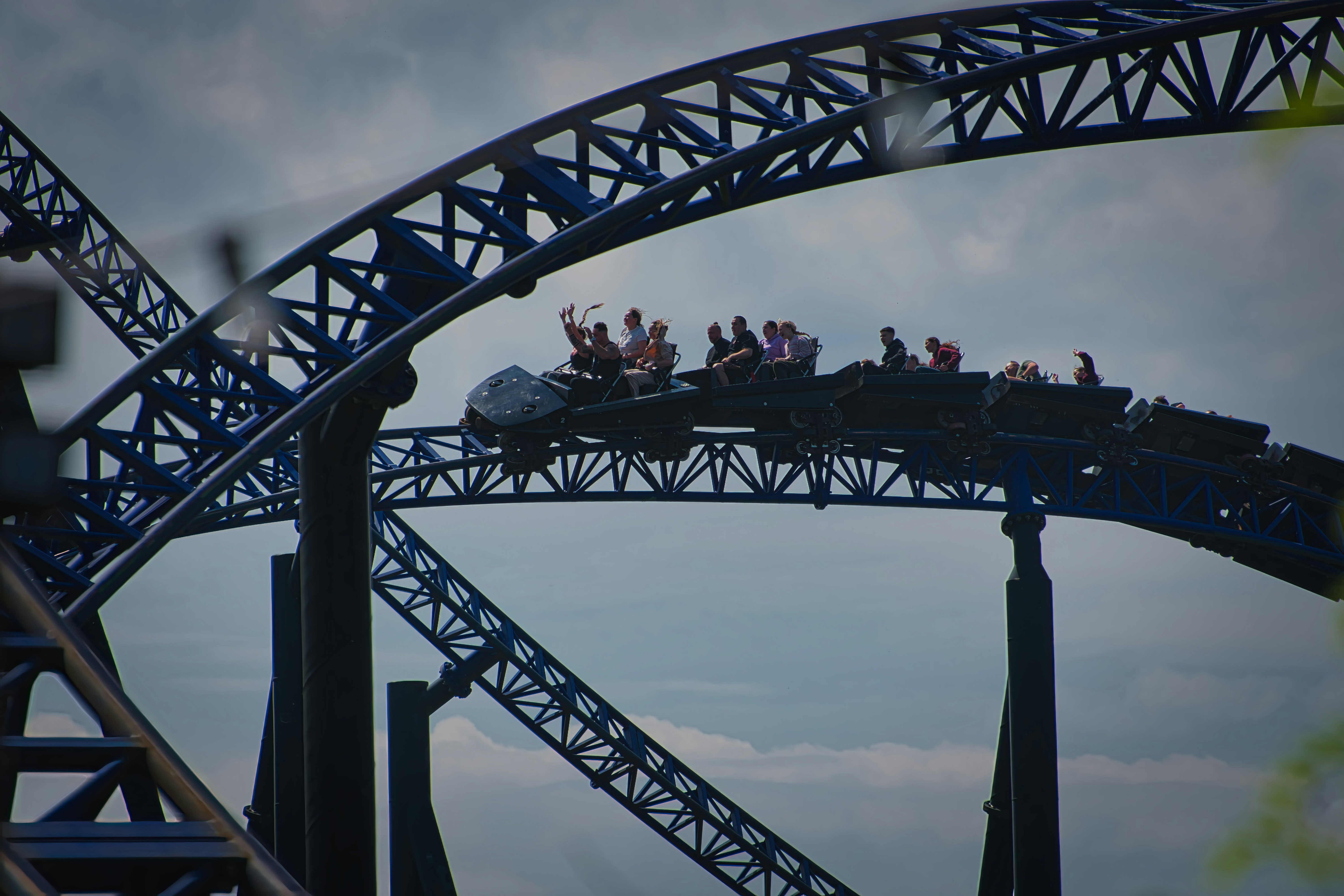 Blue Steel Helix: Riders Crest a Loop Beneath the Sky