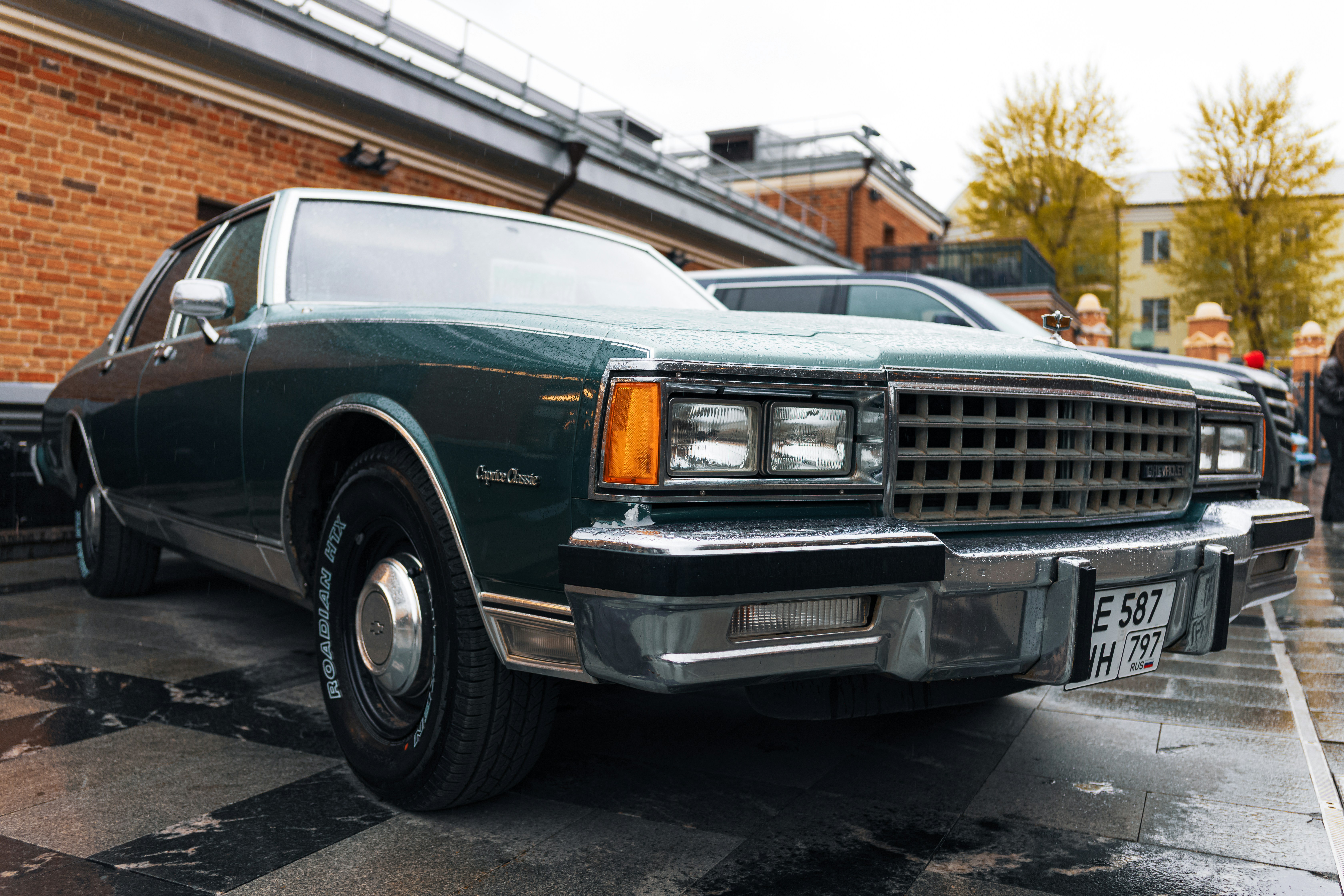 Lonely Green Cadillac: A Classic on Wet Pavement