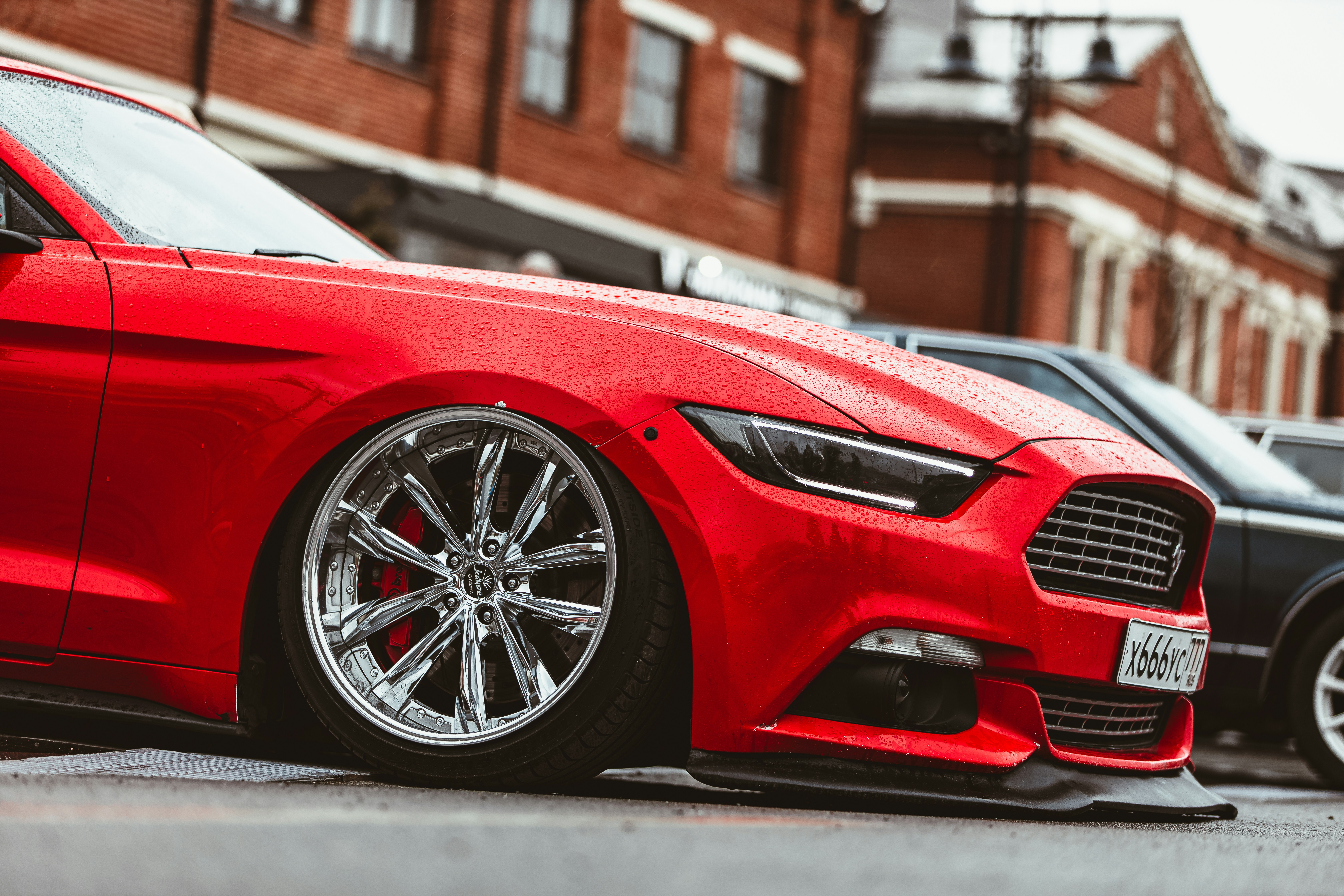 Low-Angle Red Racer: Chrome Wheels and V-Shaped Grille