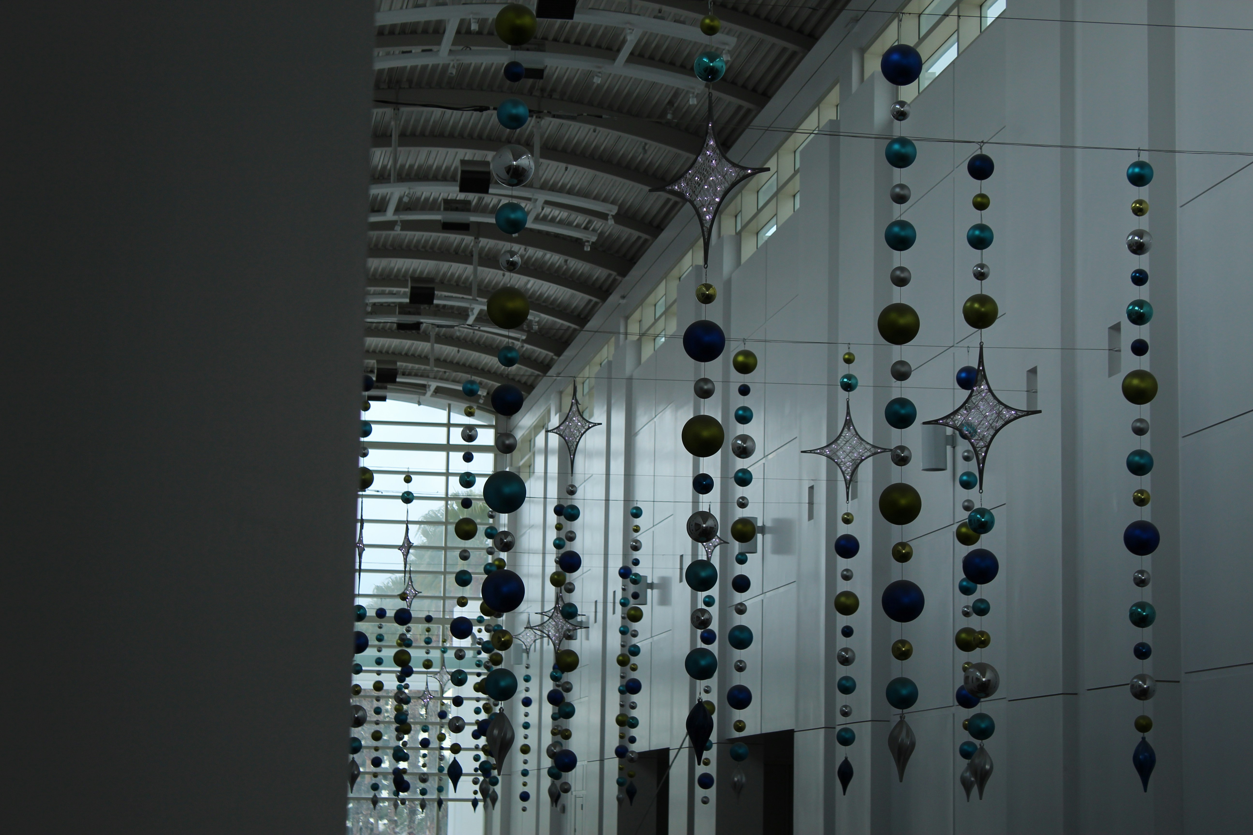 Suspended orbs in a sunlit arcade