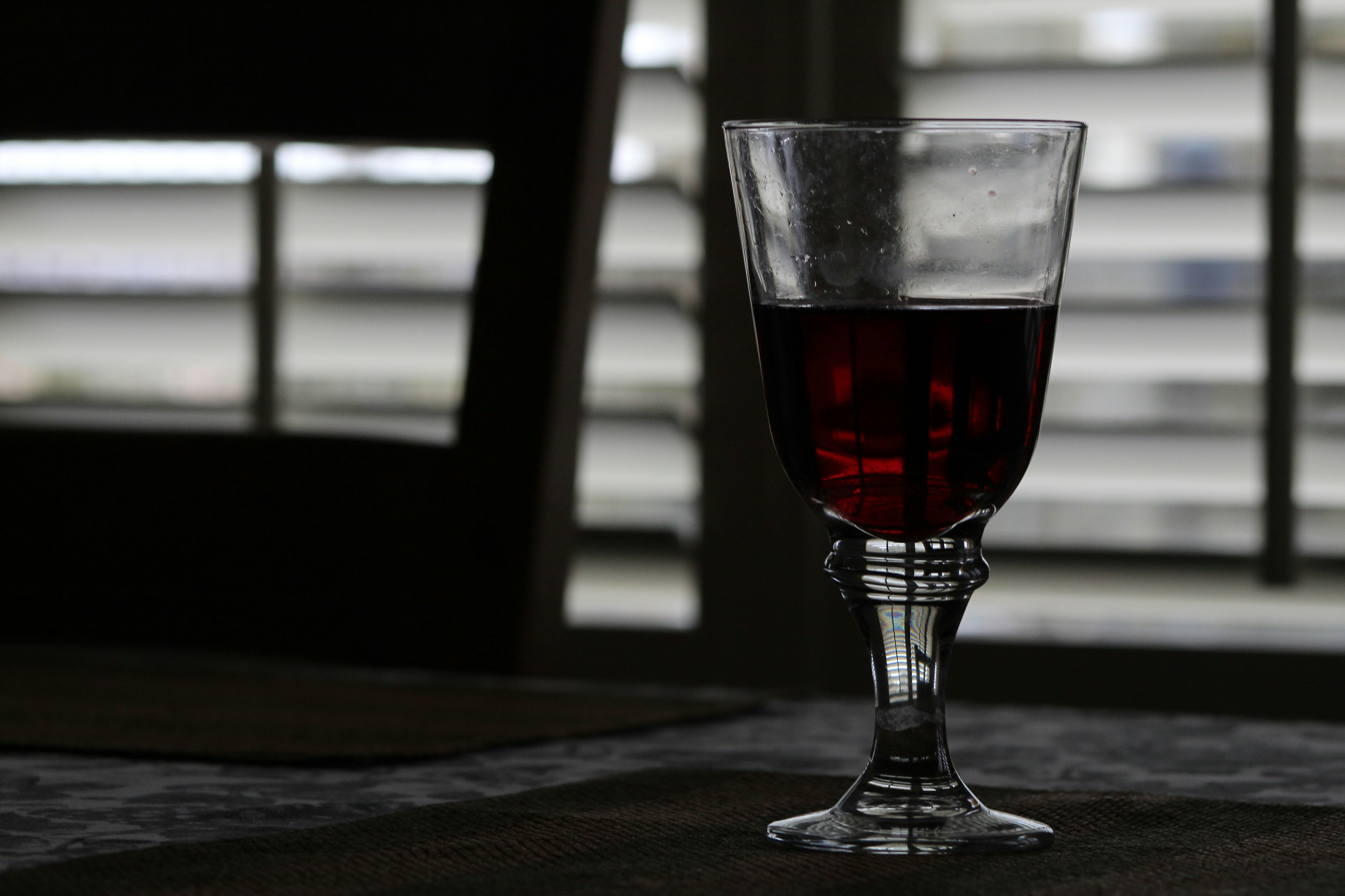 Crimson Glass at Dusk: A Quiet Pour by the Window
