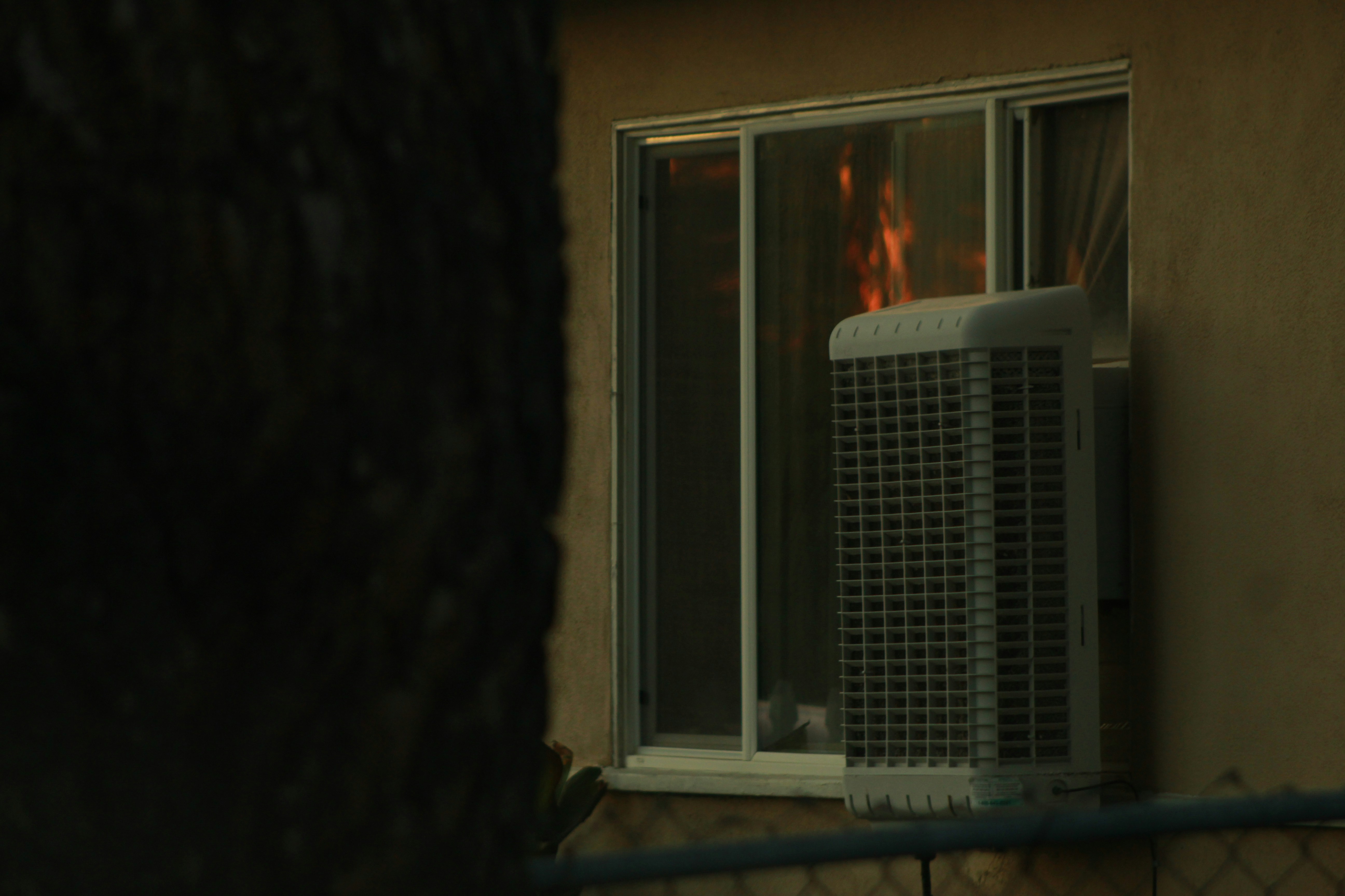 Air Conditioner as Silent Sentinel: Window Scene with Firelight Reflections
