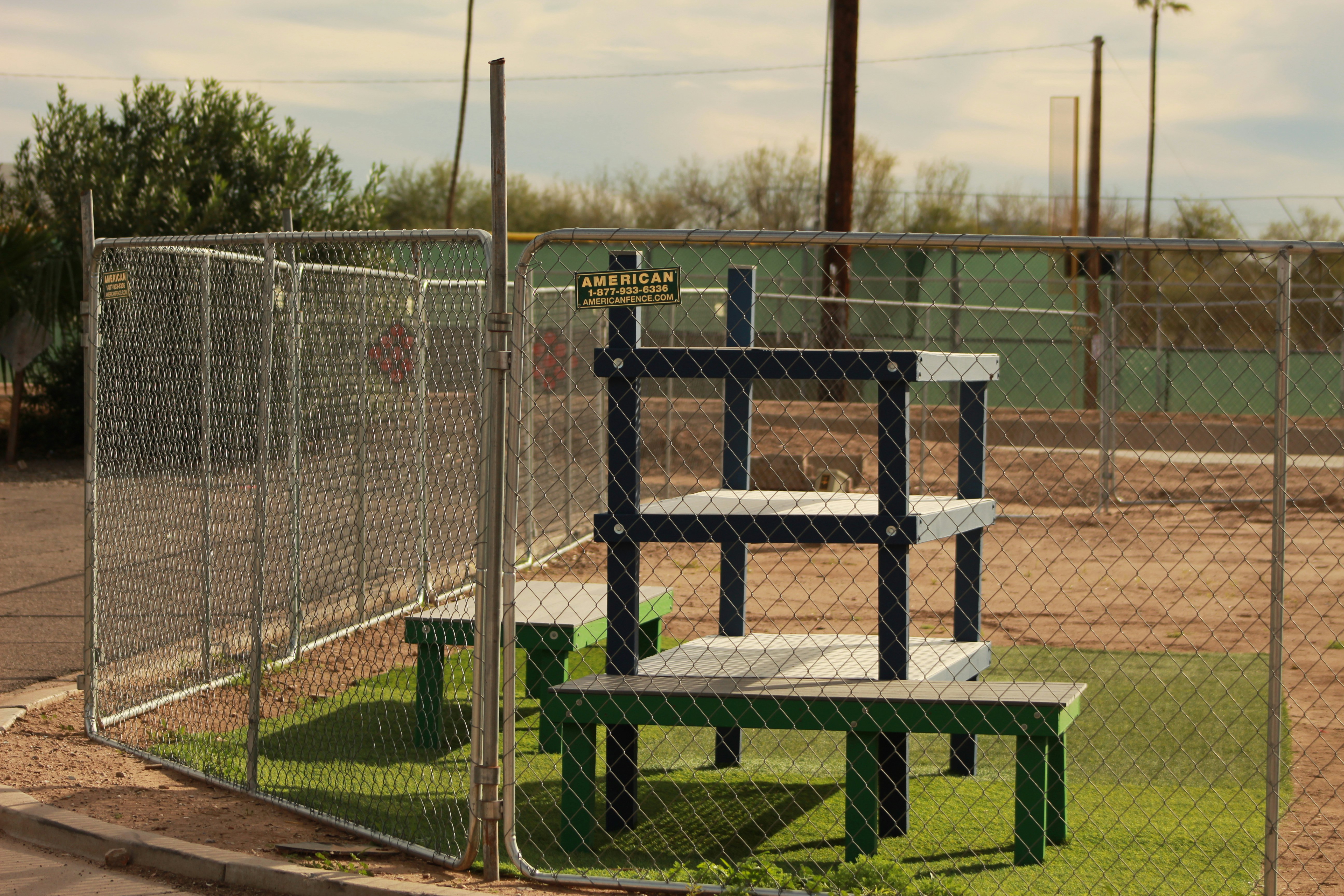 Empty Baseball Dugout Standwatch Under Chain-Link Silence