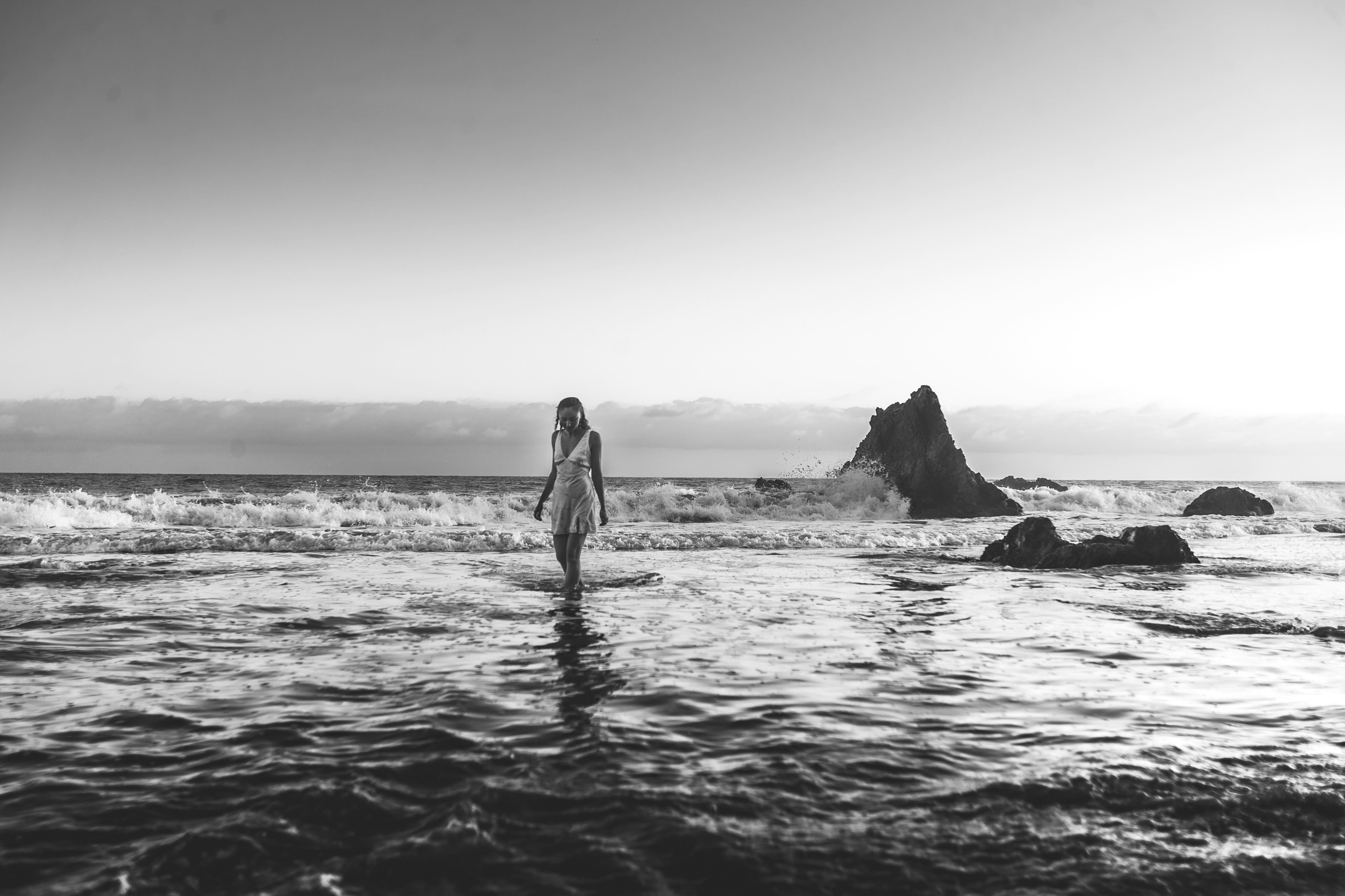 Solitary figure at the edge: a lone wanderer amid tidal rocks
