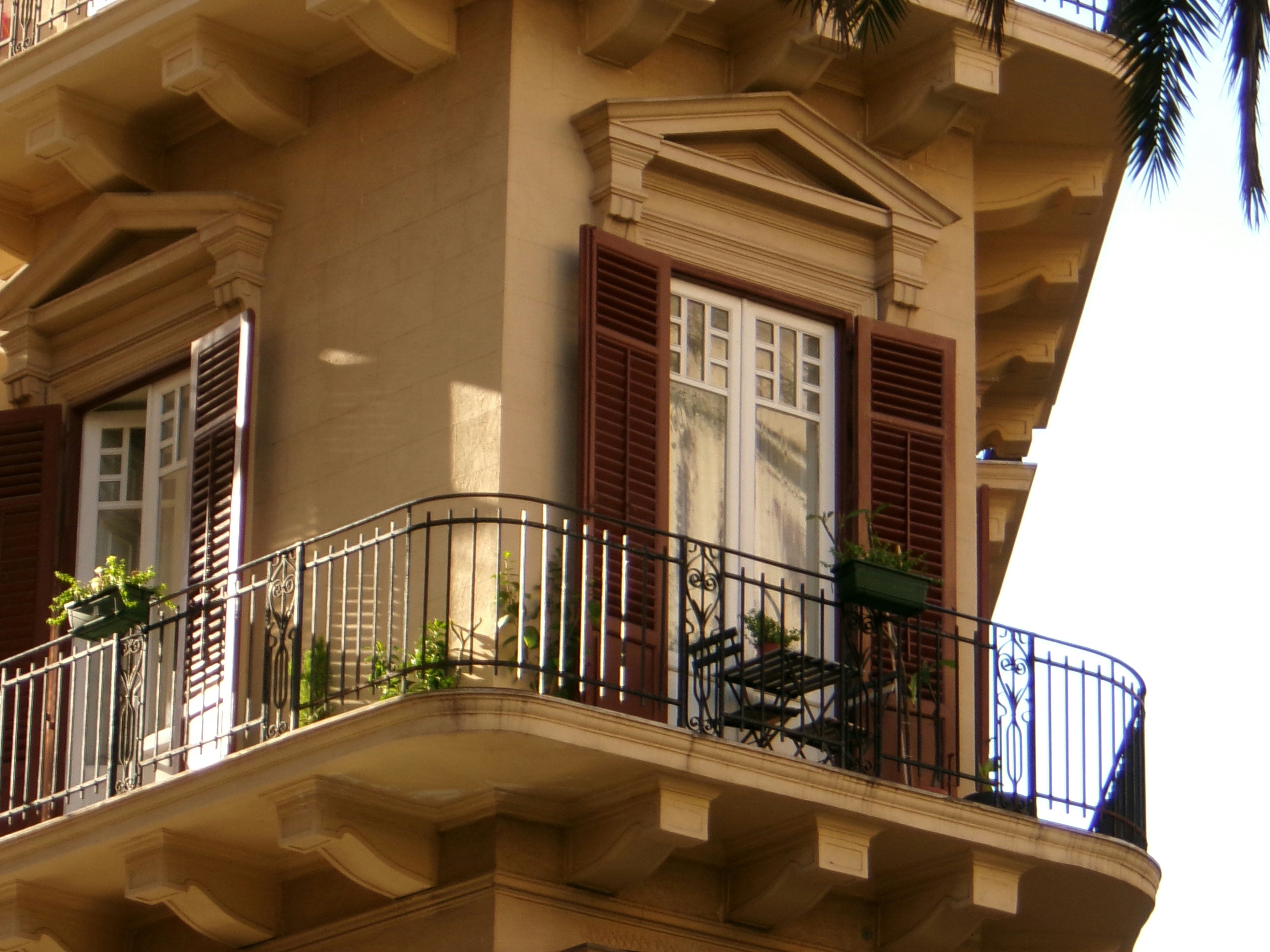 Balcony Corner with Open Shutters and Plant Pots