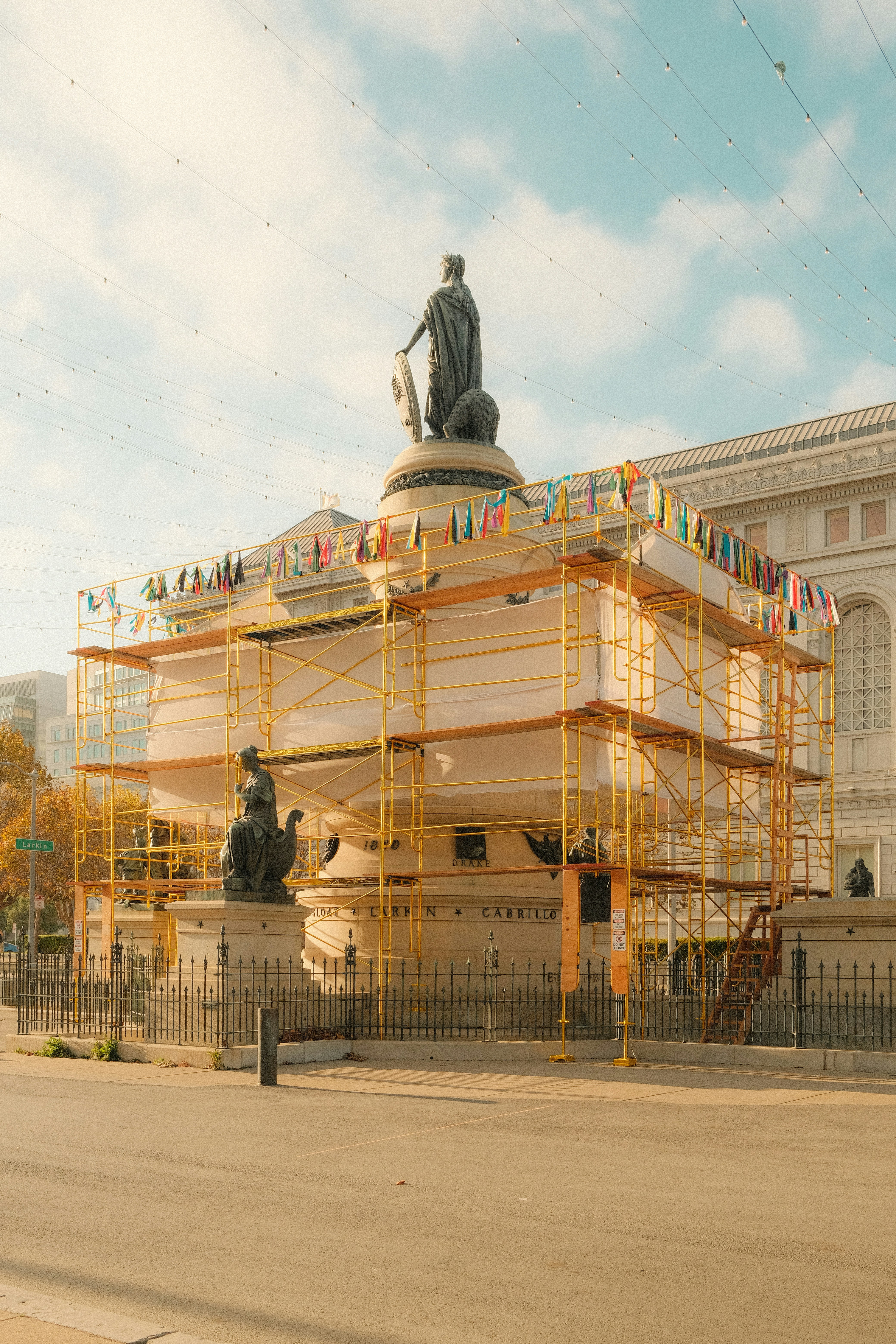 Statuary scaffolding: a monument under renovation with colorful flags