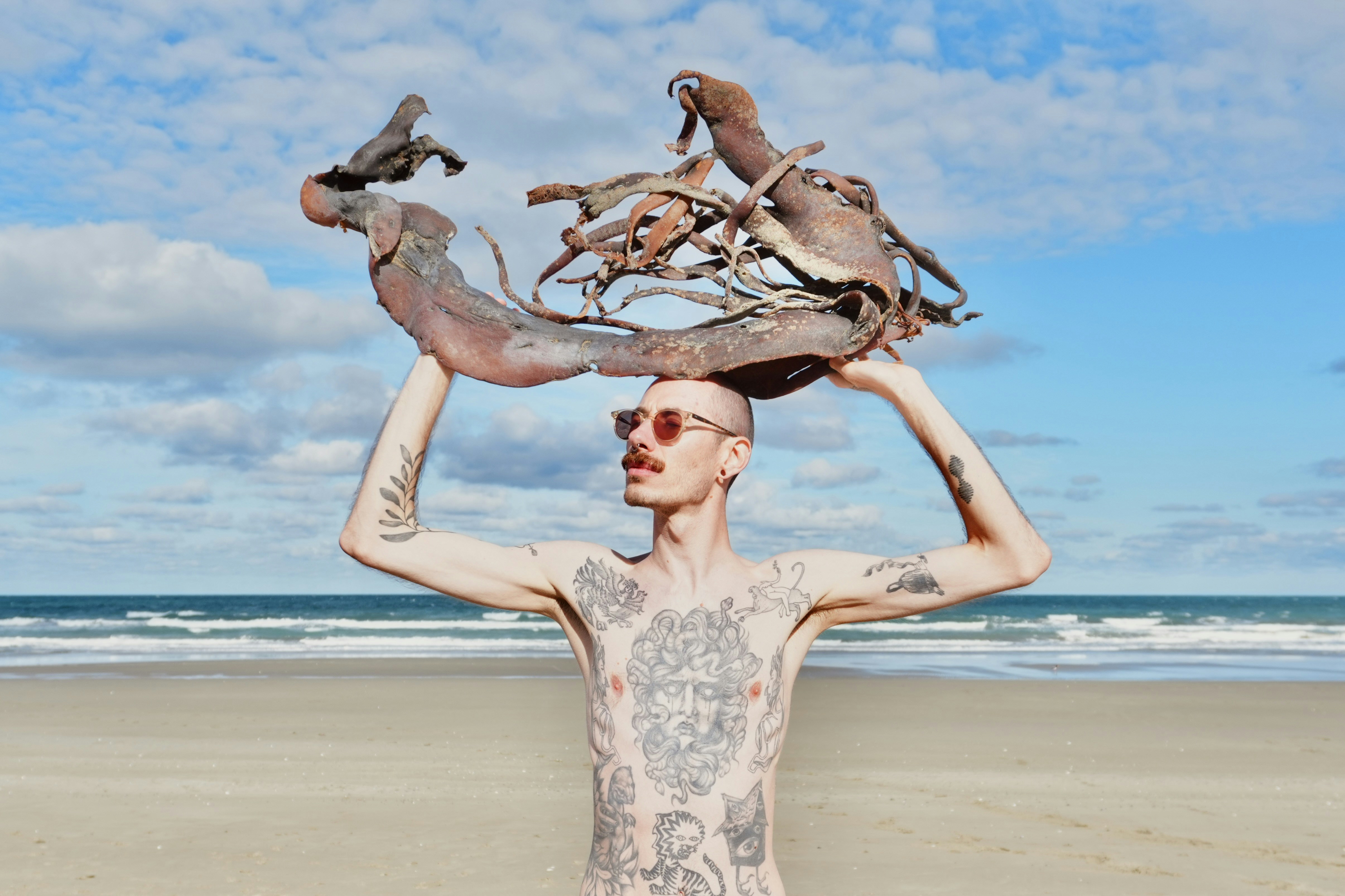 Bare-Chested Man Lonses the Sea with Dehydrated Driftwood Crown