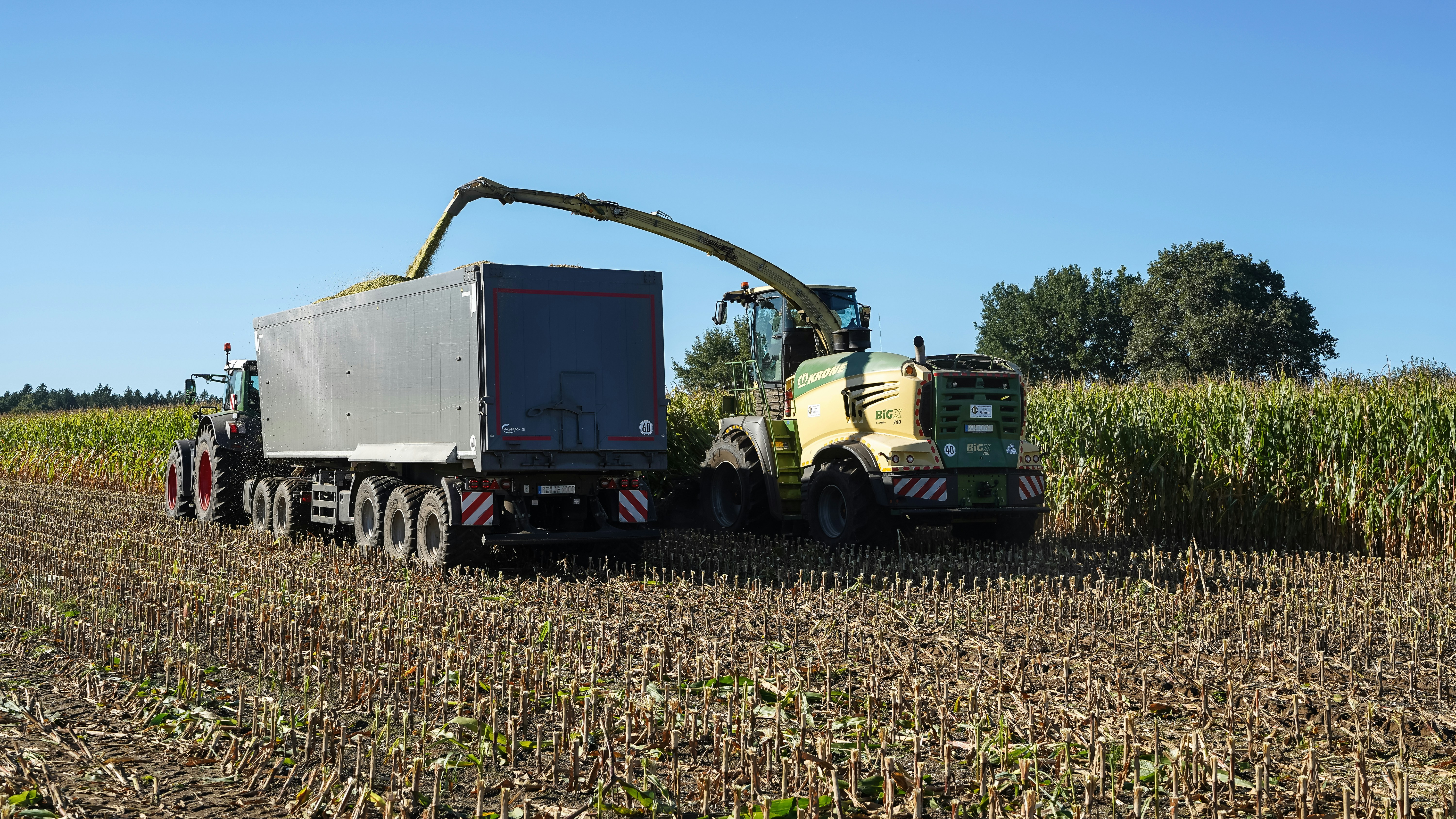 Harvest in Progress: A Tractor Unloads Into a Grain Trailer