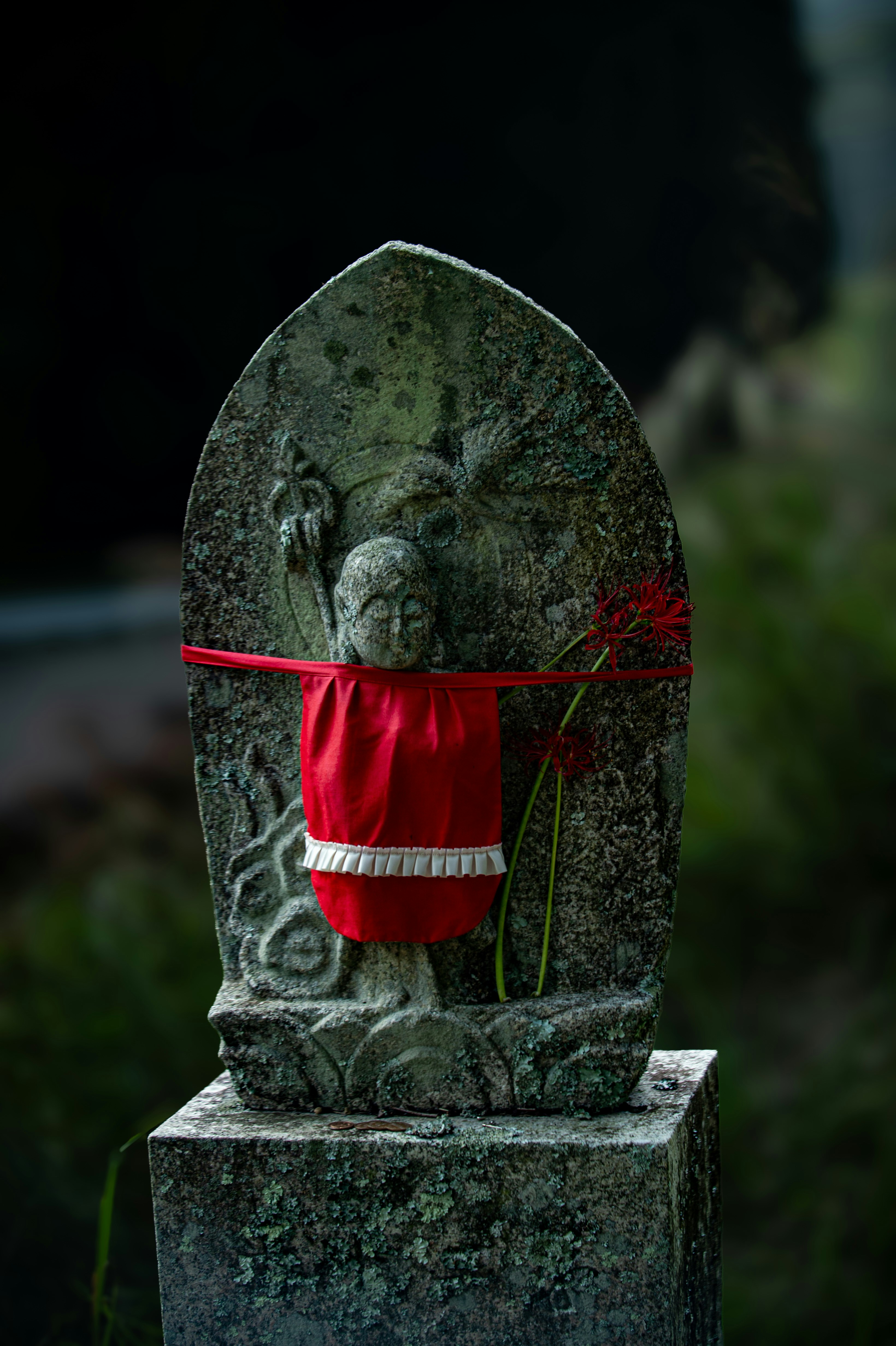 Red Cloth Shrine: A Weathered Stone Figurine Bound by Crimson Ribbon