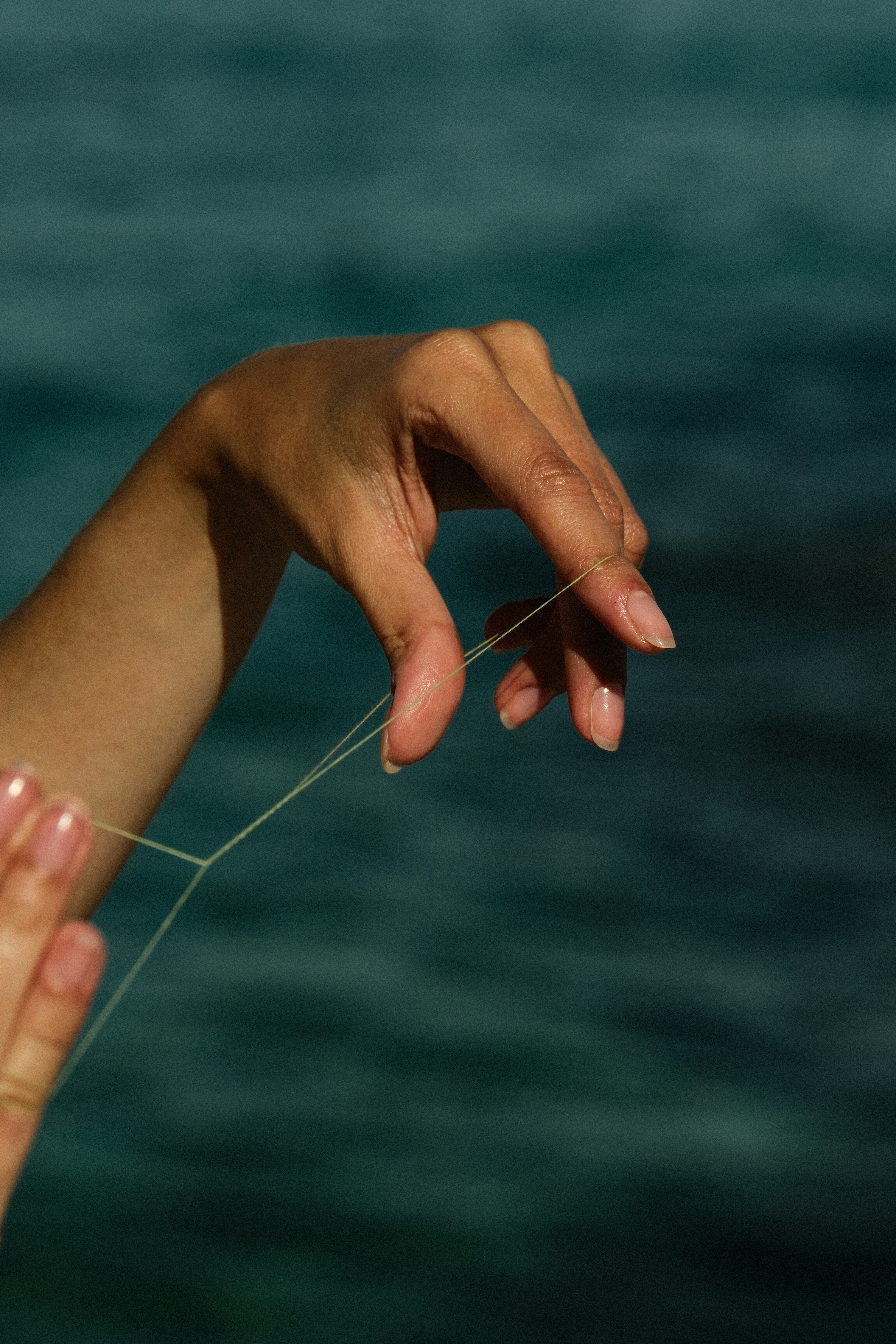 Threads of Focus: A Delicate Grip by the Sea