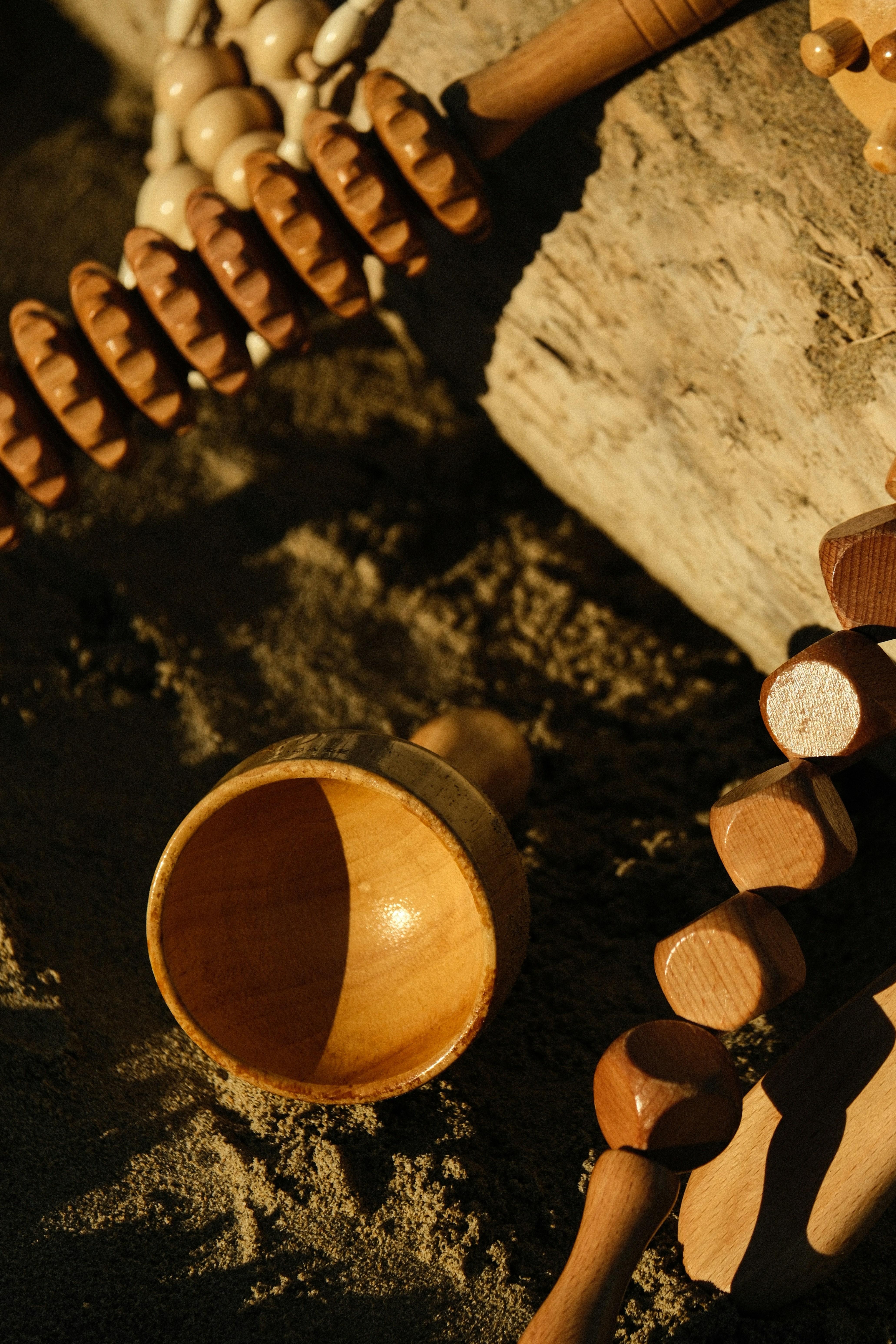 Amber playthings in sunlit dust: a courtyard of carved wooden beads and vessels