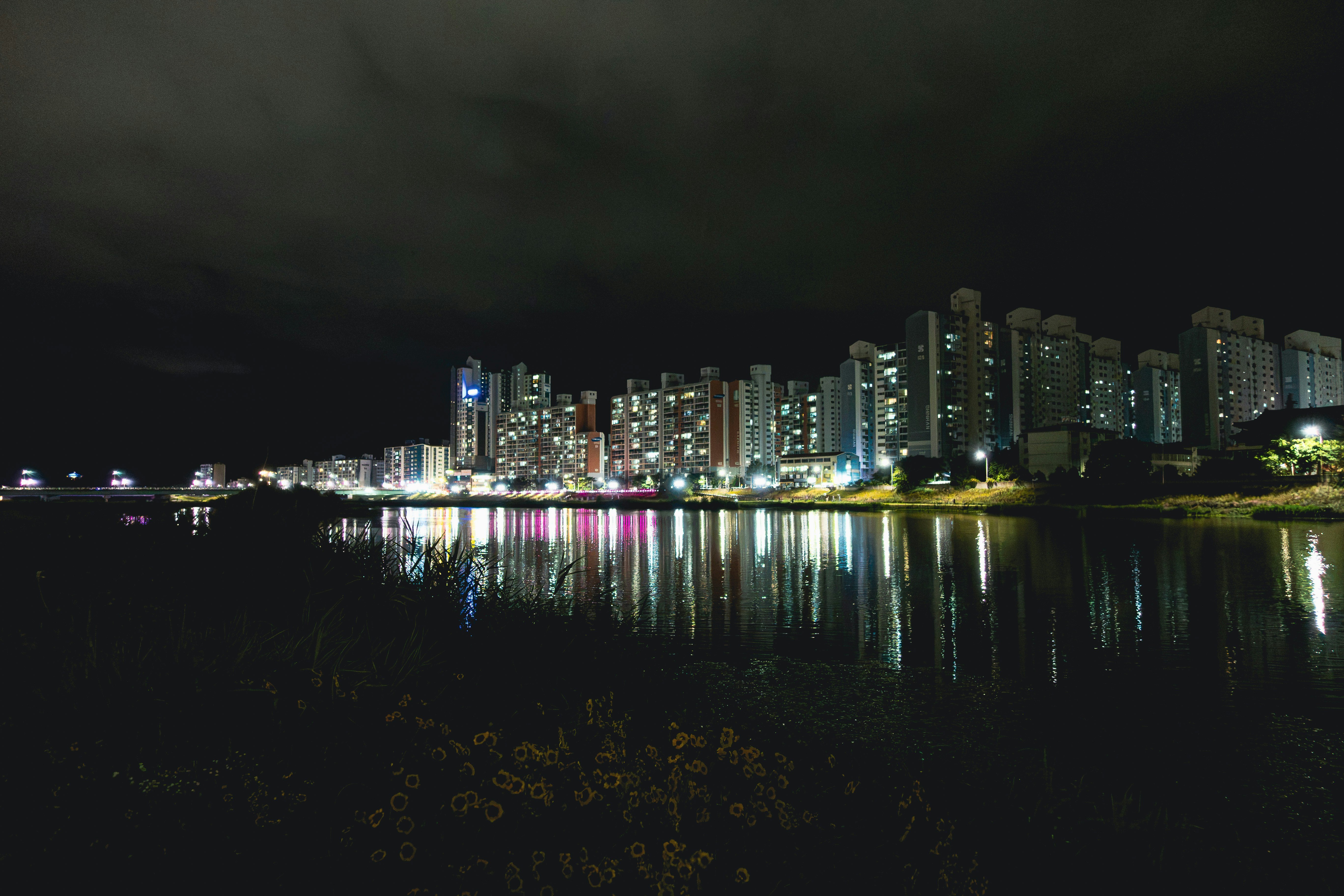 Moonlit Skyline Ripples: Neon Reflections on a Quiet River