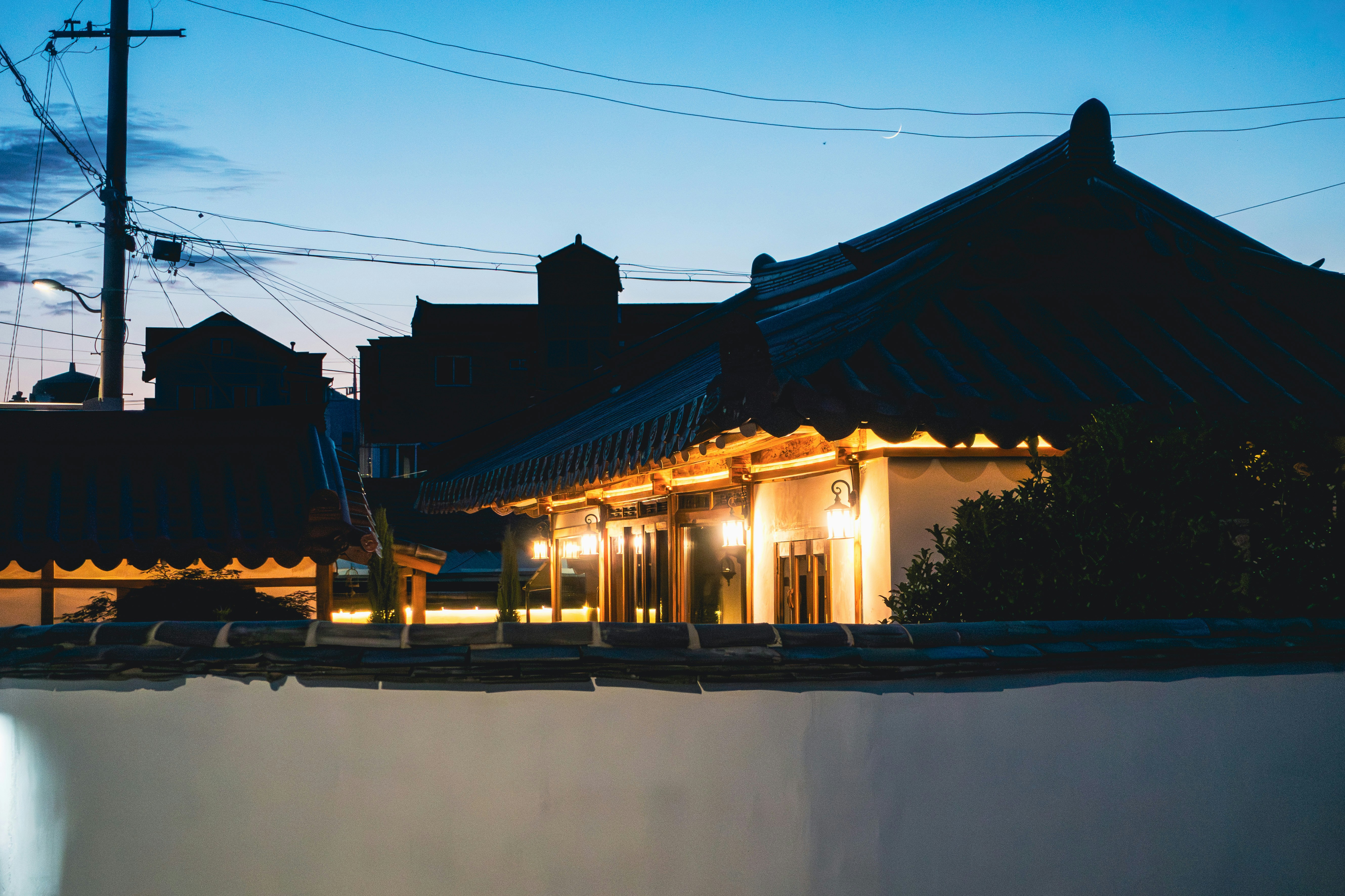 Warm Lanterns along a Quiet Traditional Roofline at Dusk