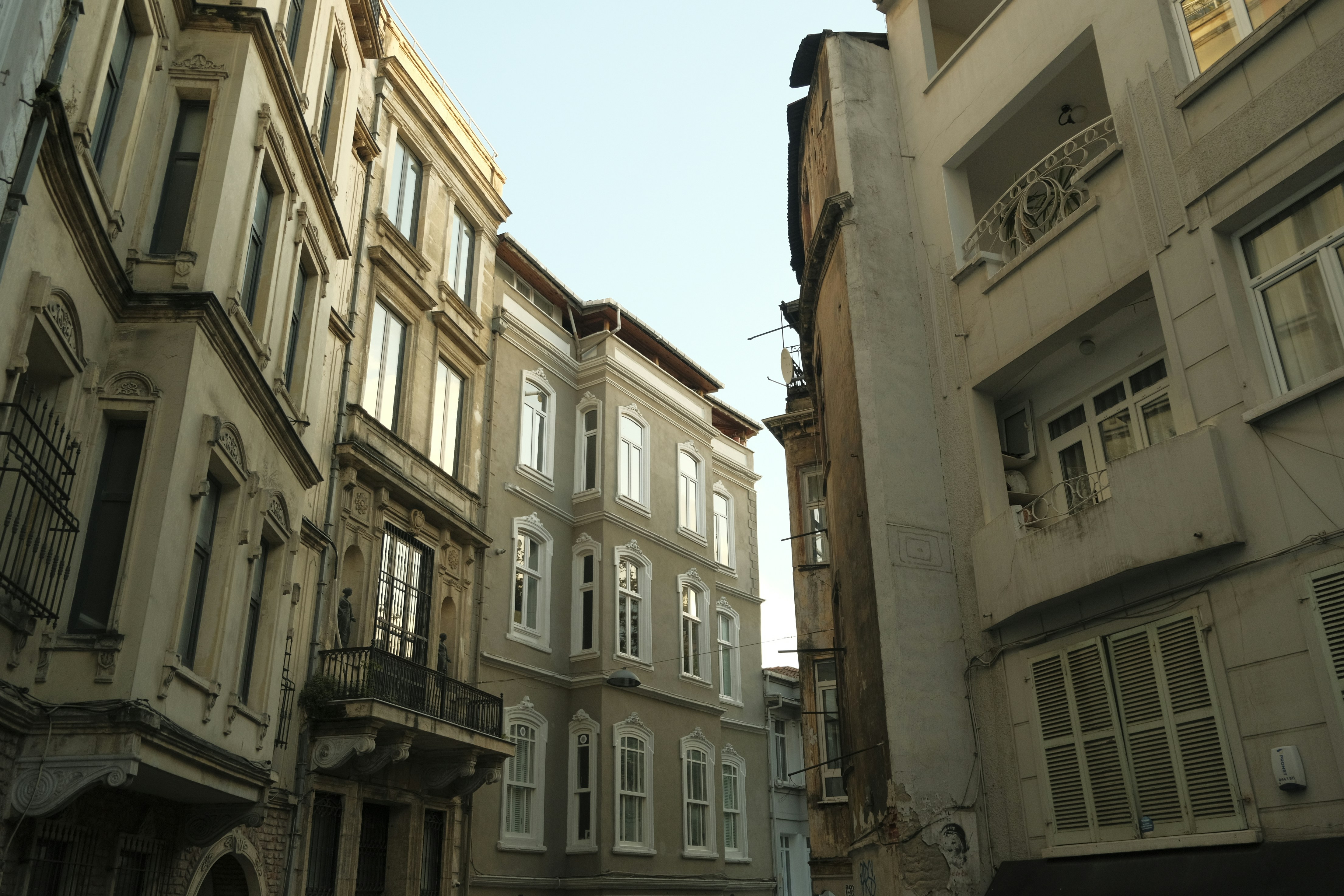 Sunlit Alleyway Between Faded Facades