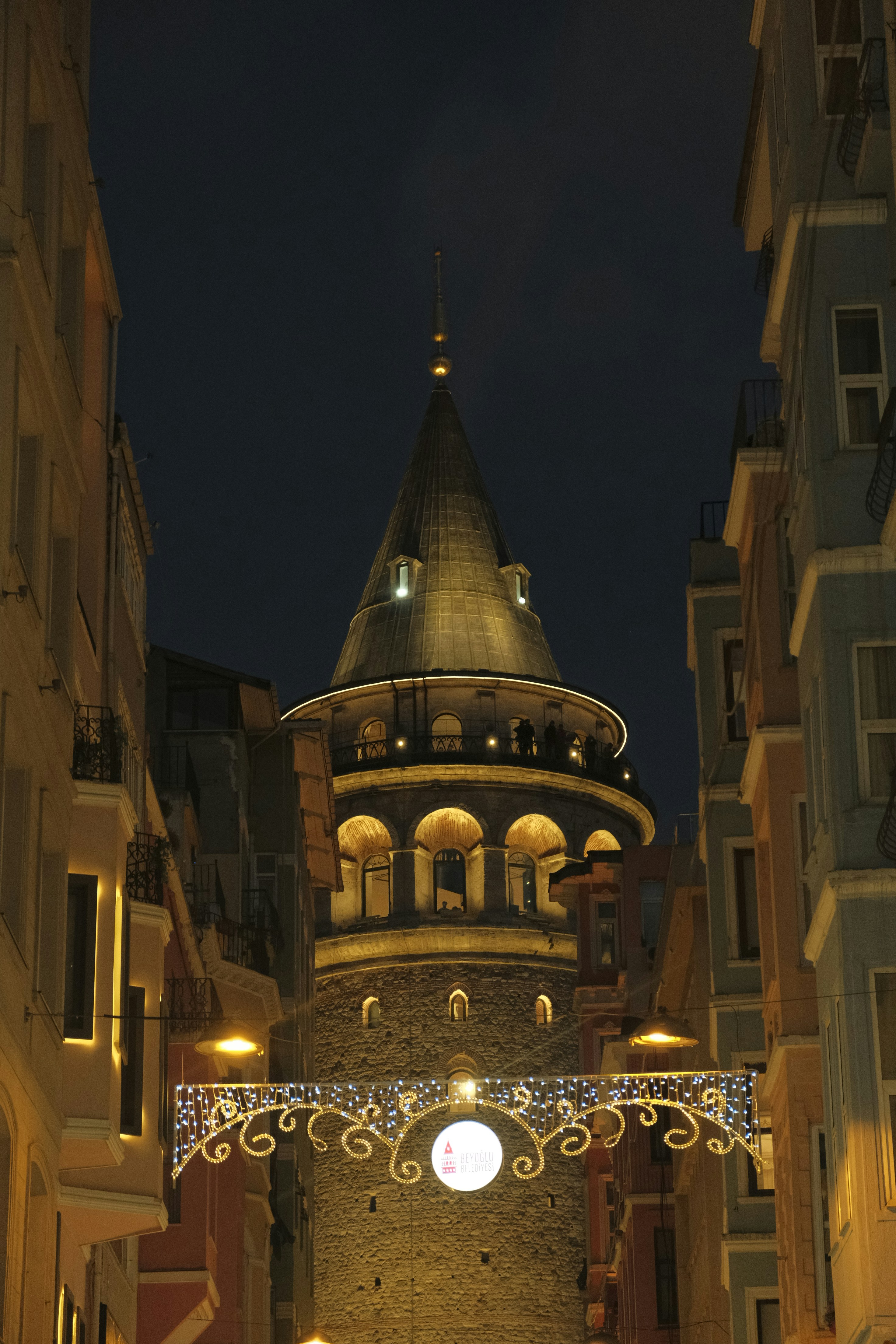 Illuminated Gatekeeper: A Night Portrait of the Tower Under Soft Street Glow