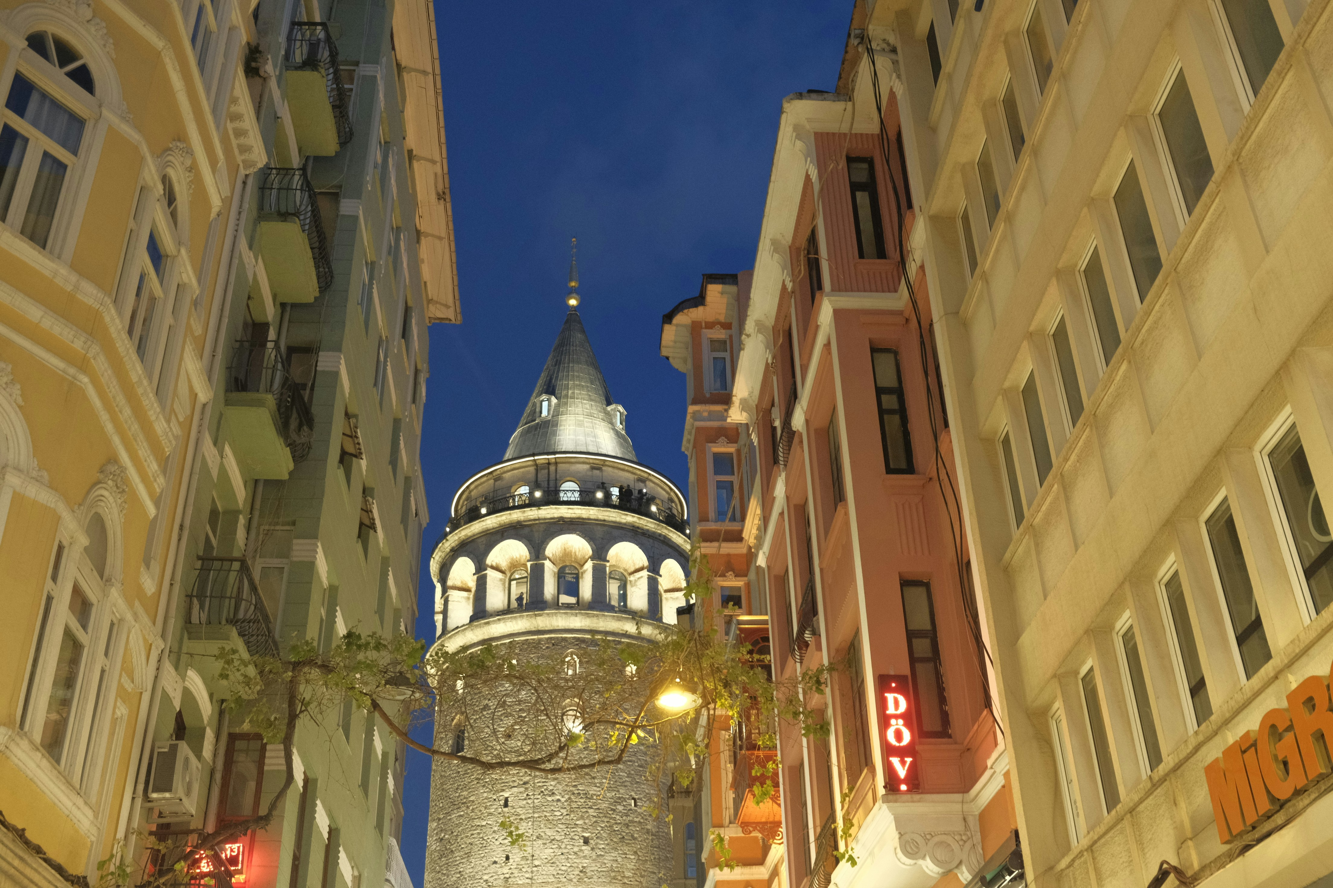 Turreted Tower Rising Between City Arches at Dusk