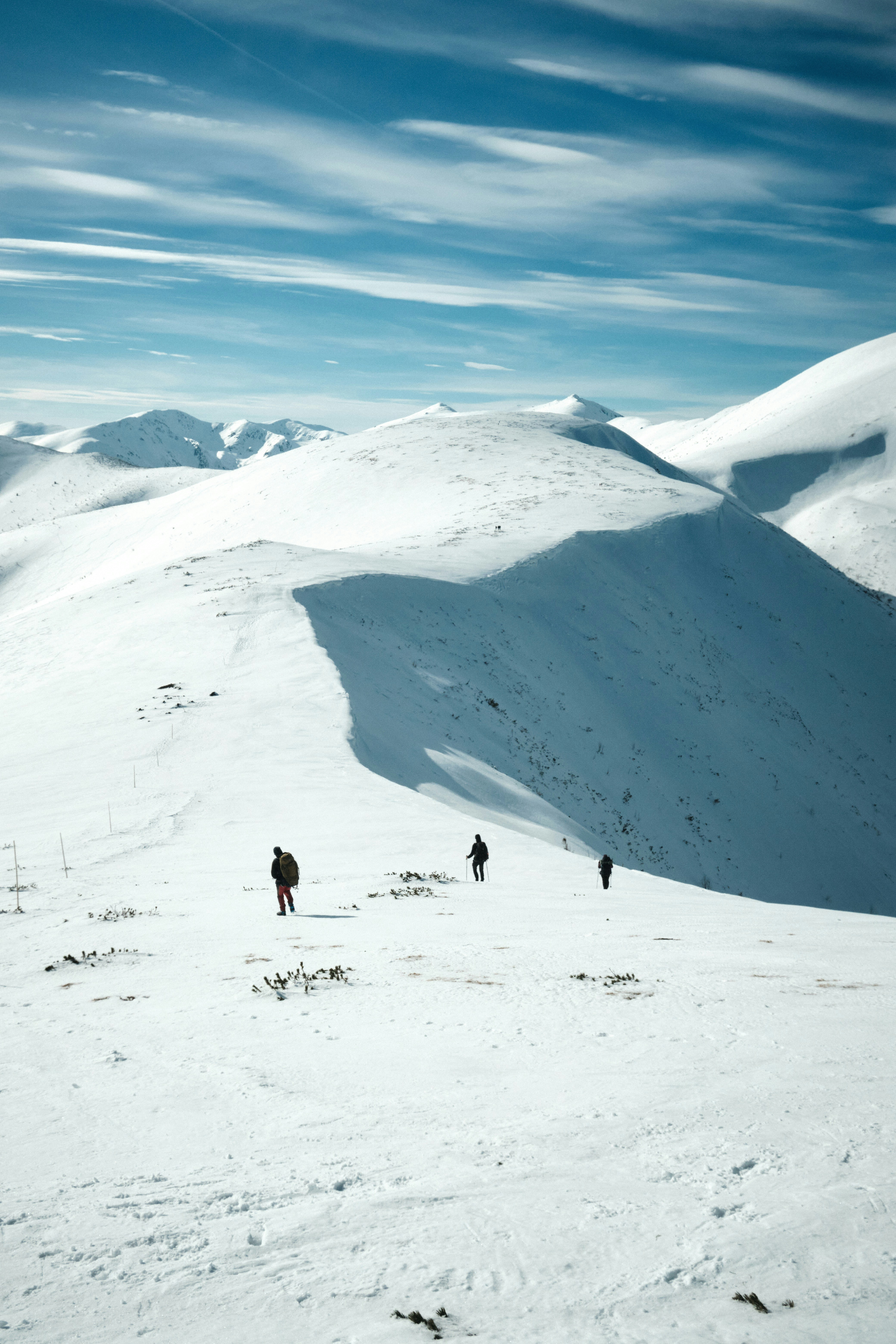 Snowbound Sentinels: Climbers Carving a Path Across the Ridge