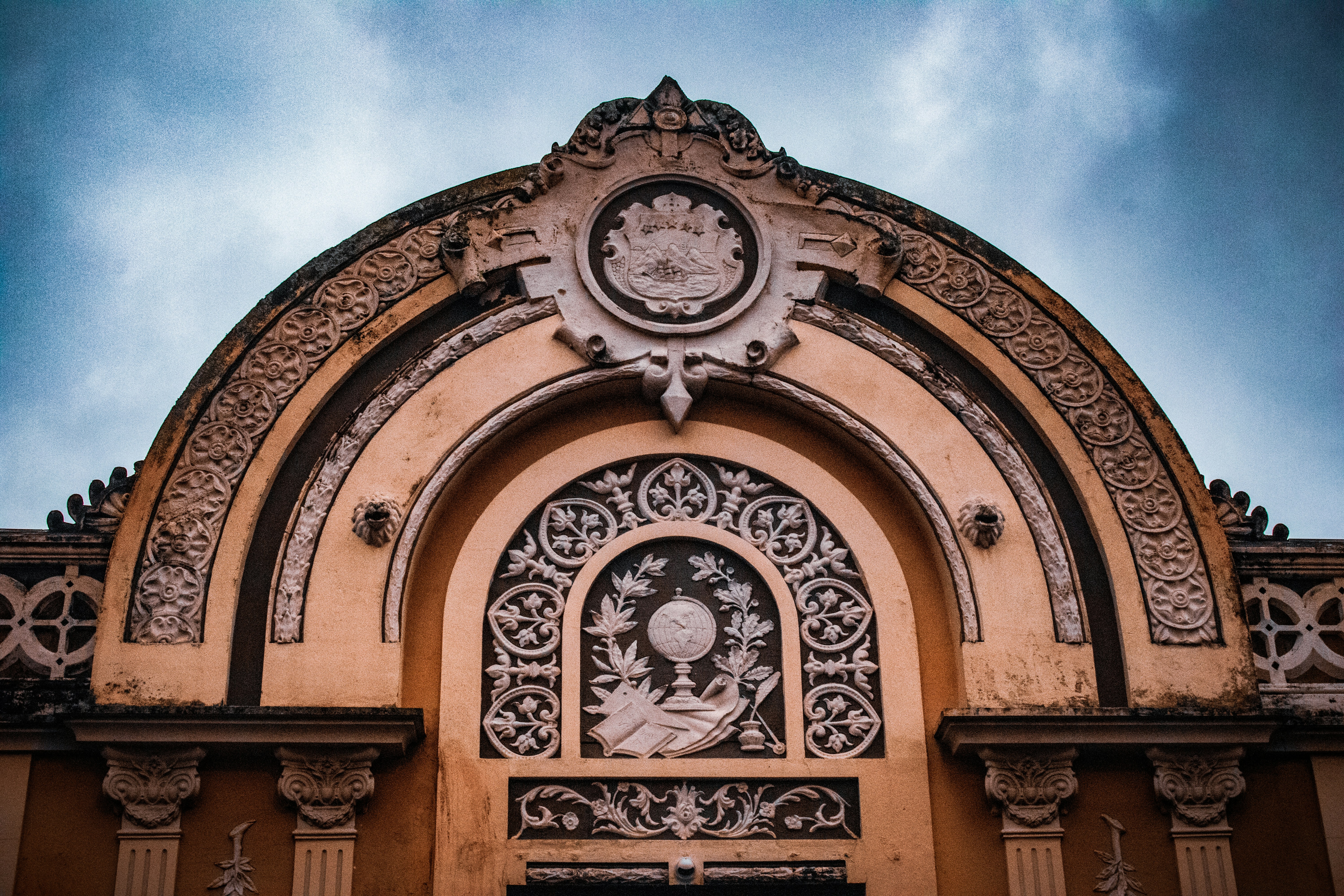 Ornate Archway Crest: Sunlit Carved Facade