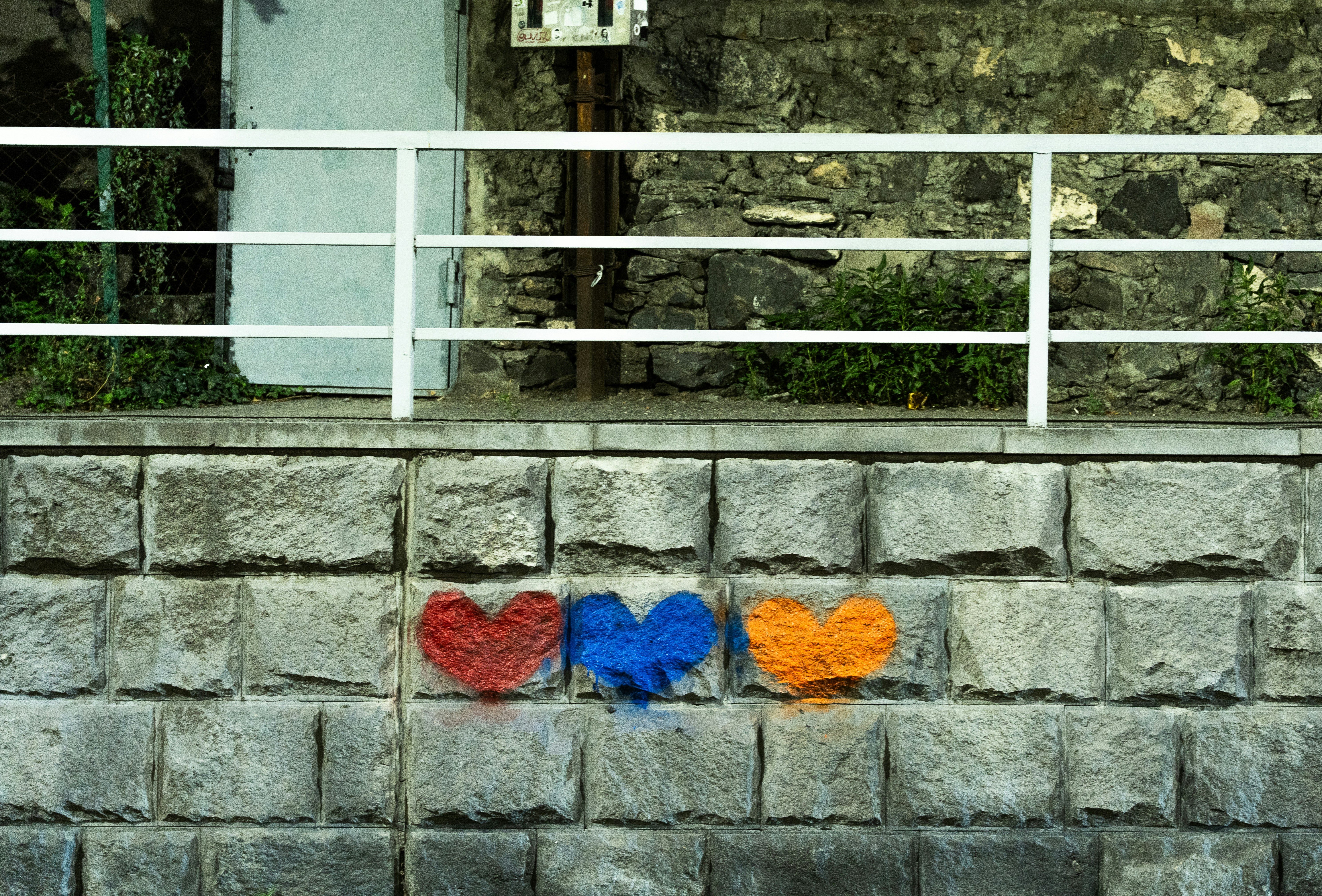 Three Painted Hearts on a Weathered Stone Wall