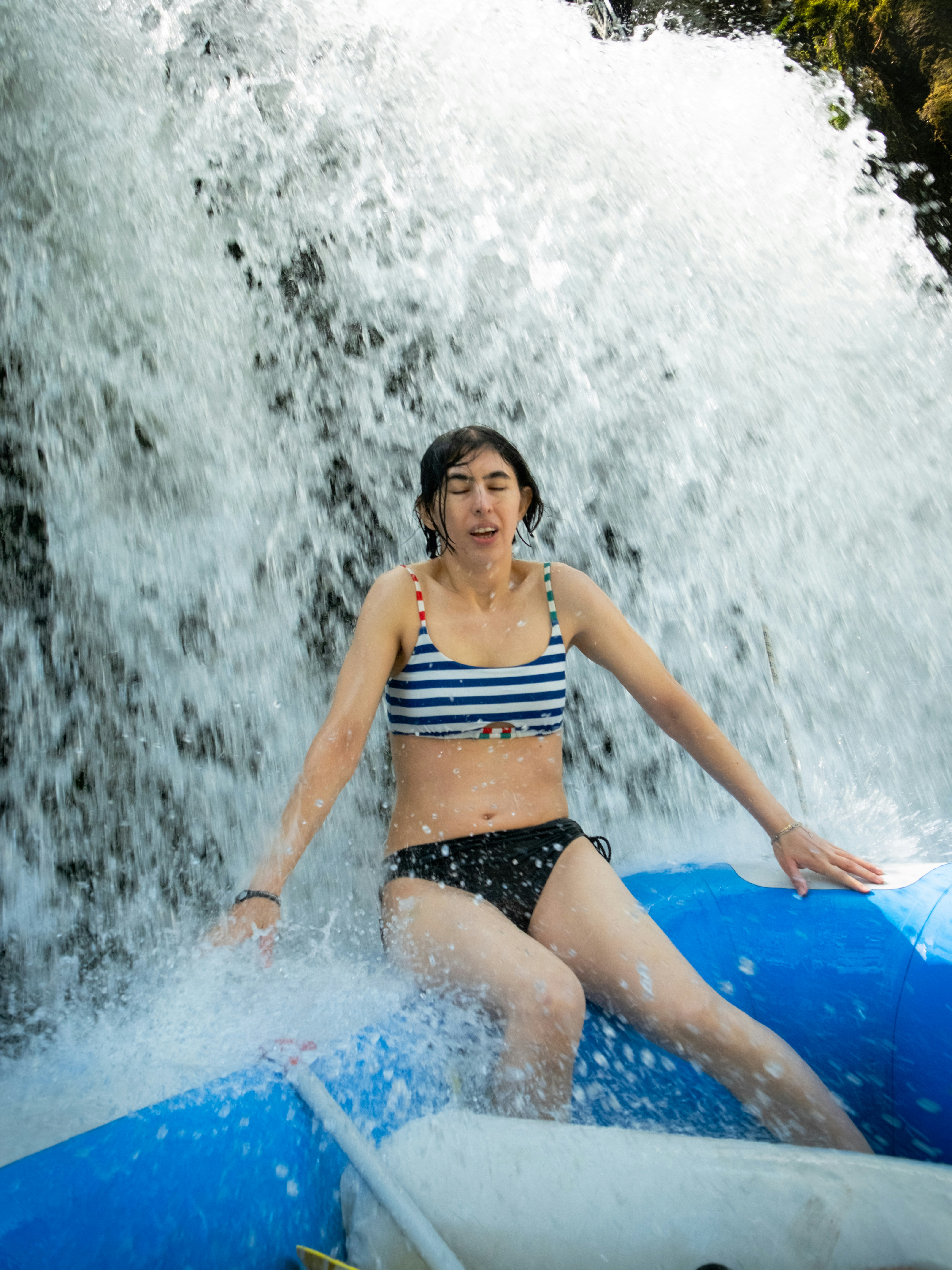 Cascading Waterfall Moment: A Swimwear Snapshot Amid a Hydrodynamic Curtain