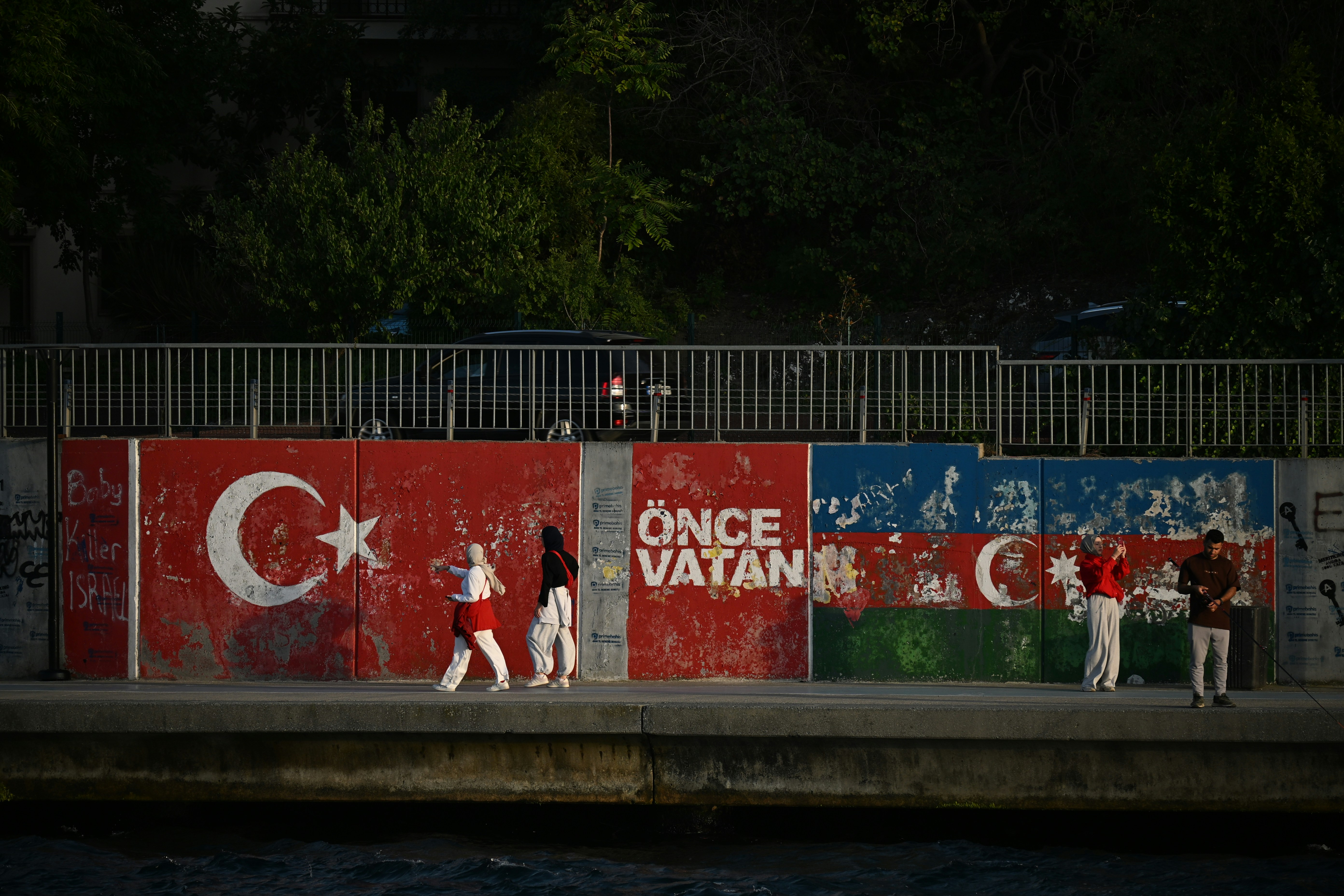 Urban Boundary: People Walking Along a Painted Turkish Wall