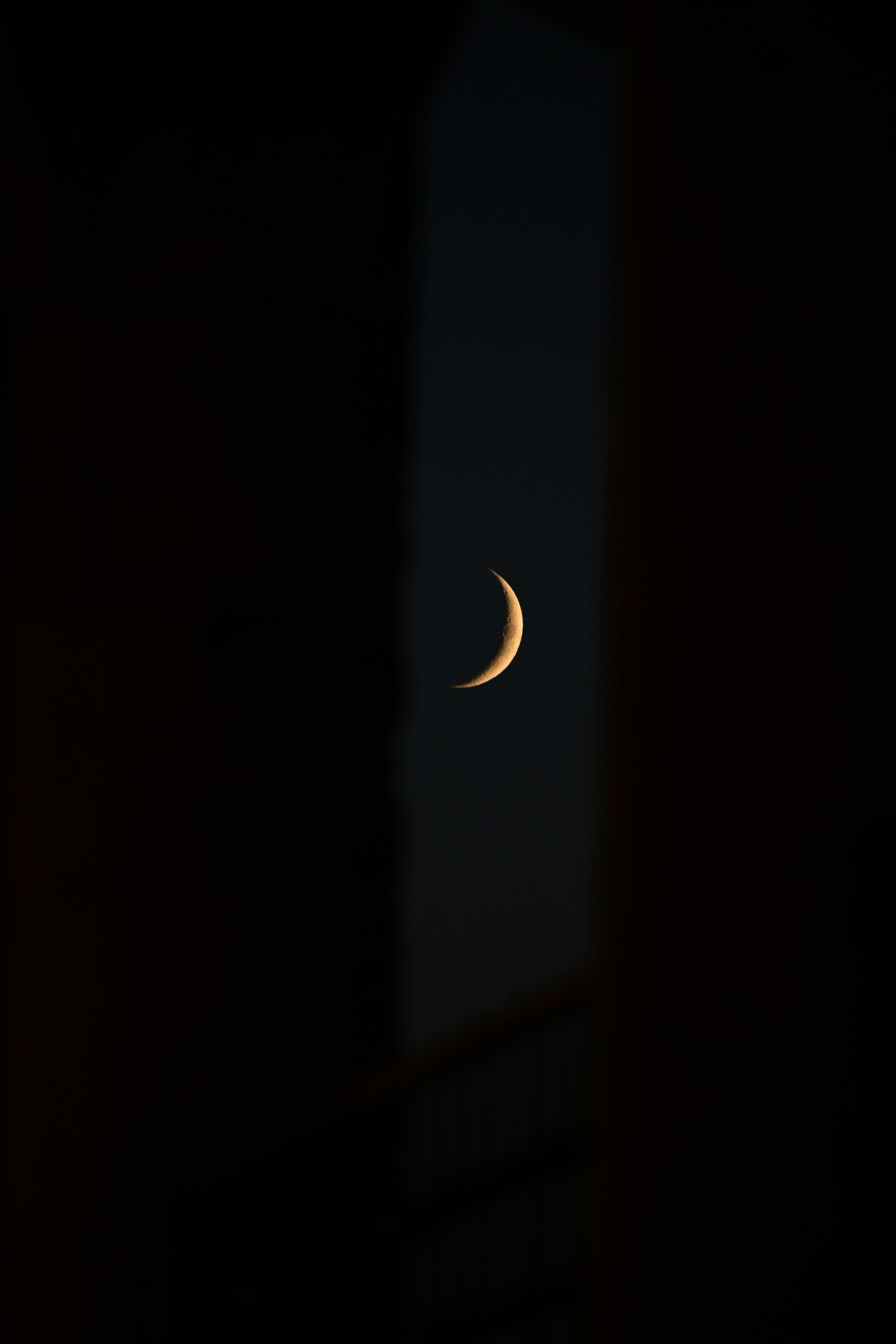 Slim Crescent in a Night Curtain: Moon Between Shadows