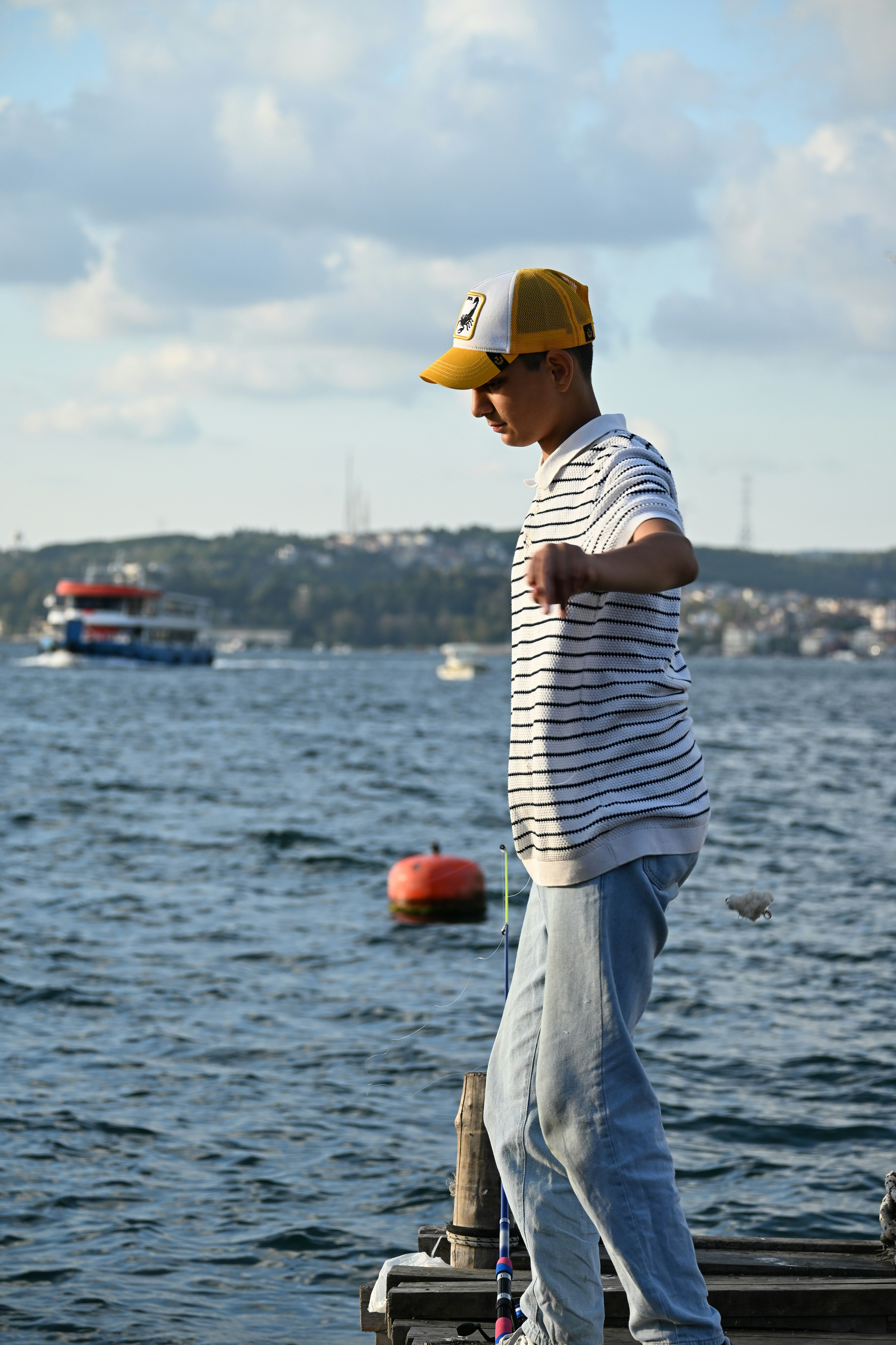 Lifebuoy and Light: A Young Angler at the Waterfront