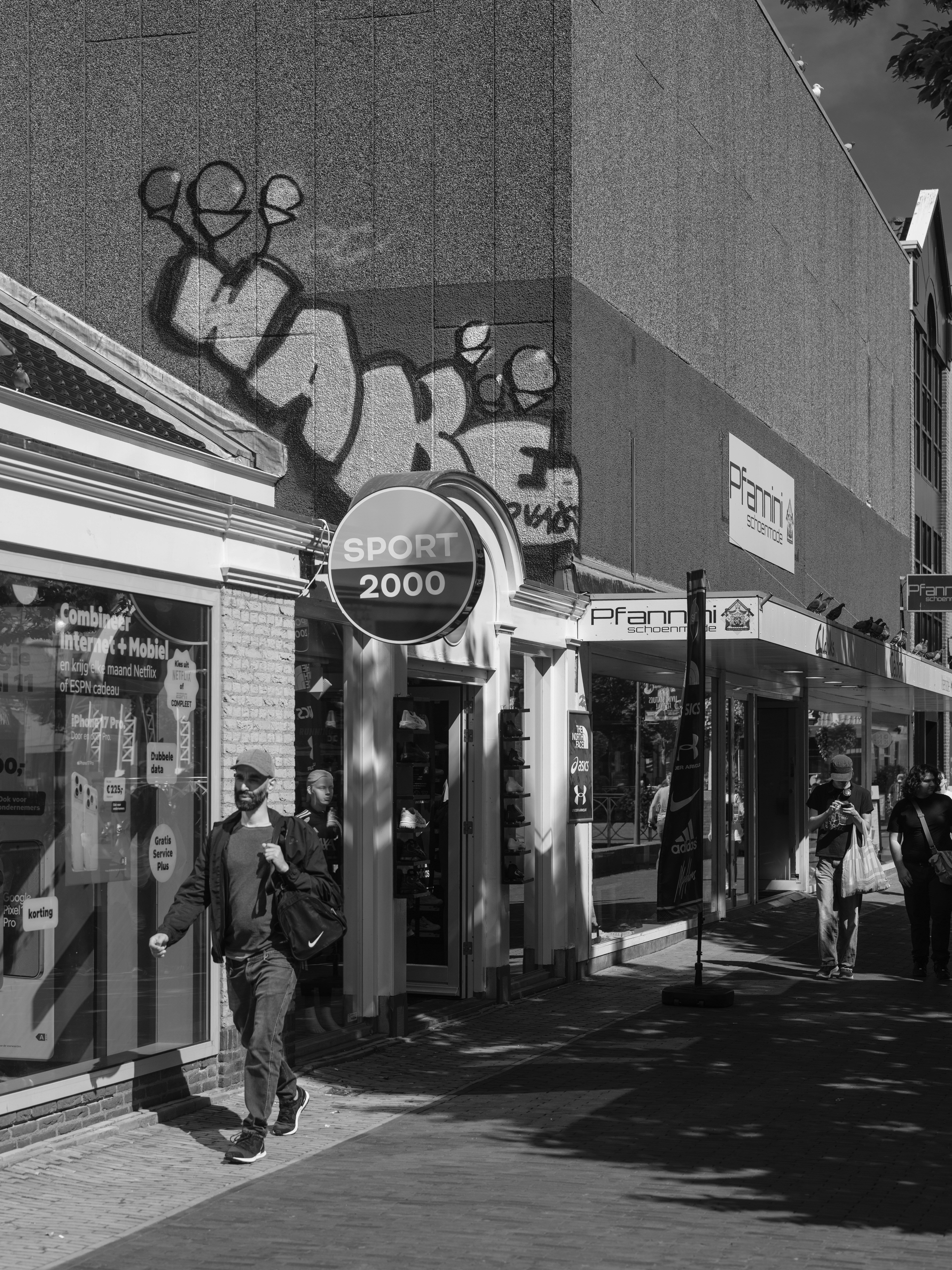 Sport 2000 storefront under graffiti-clad wall