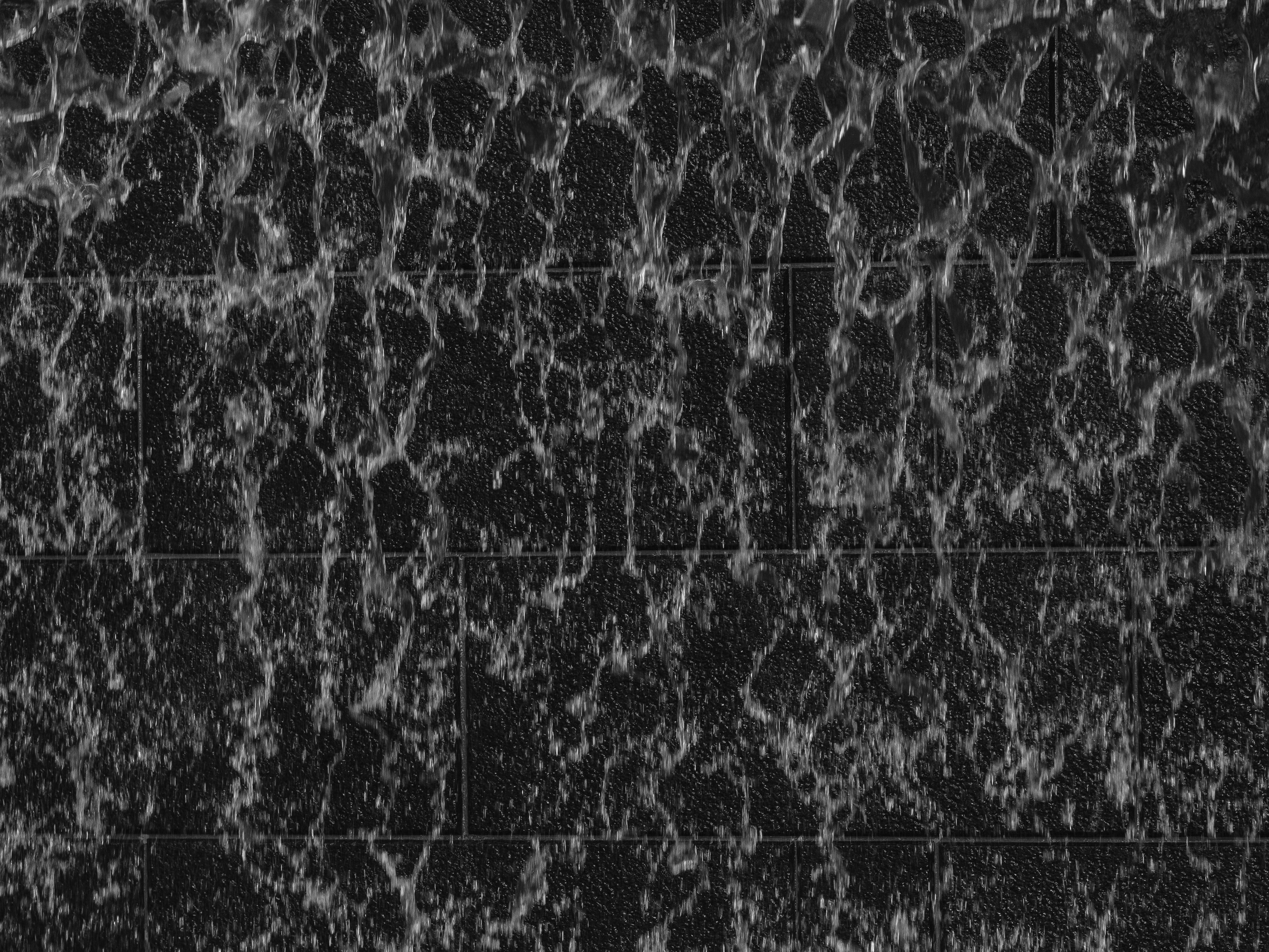 Granite Rainfall: Fragments of a Dark Wall Streaked by Water