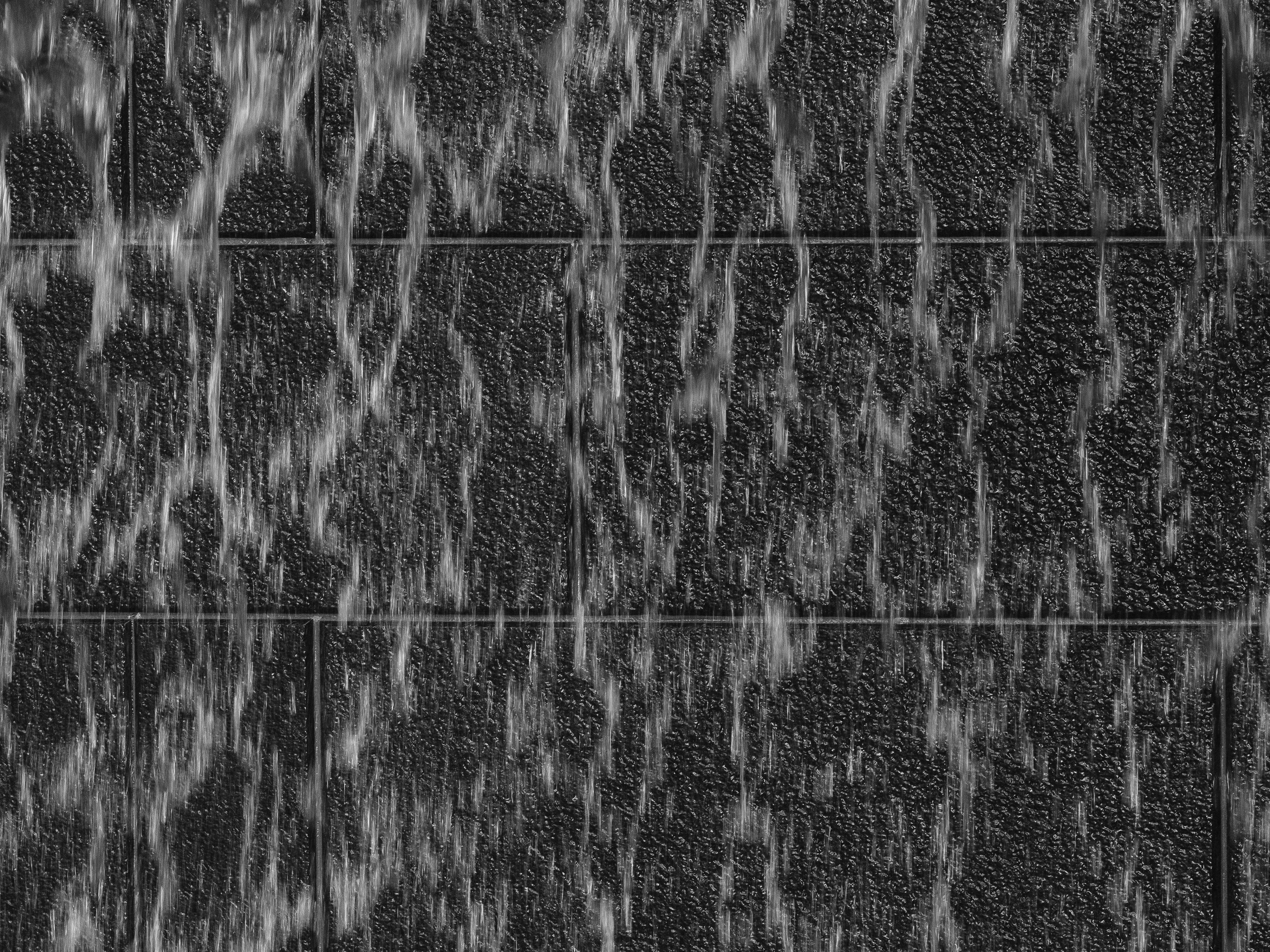 Industrial Cascade: Water Trails Across a Brushed Concrete Facade