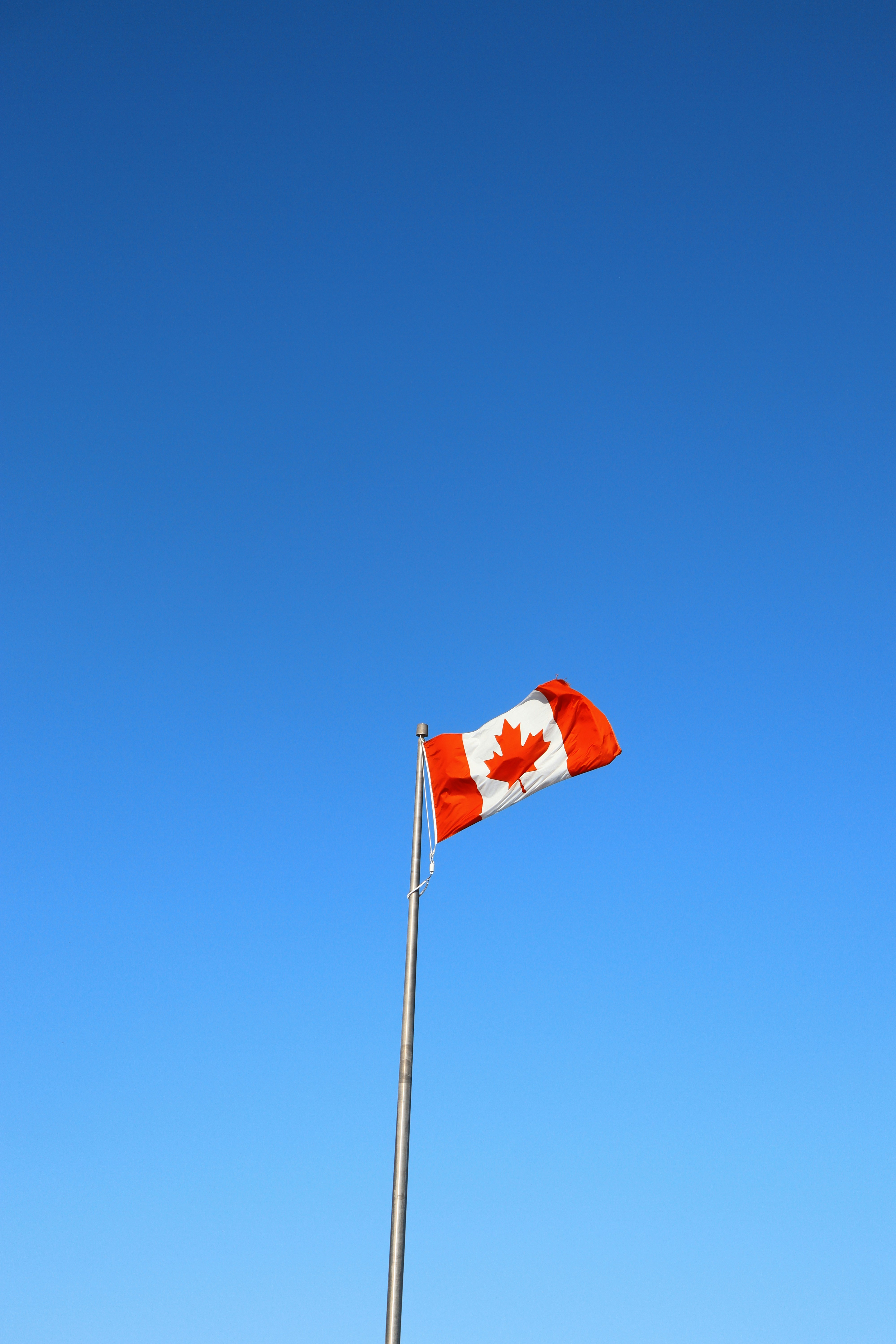Flag of Canada Adrift Under a Wide Blue Sky