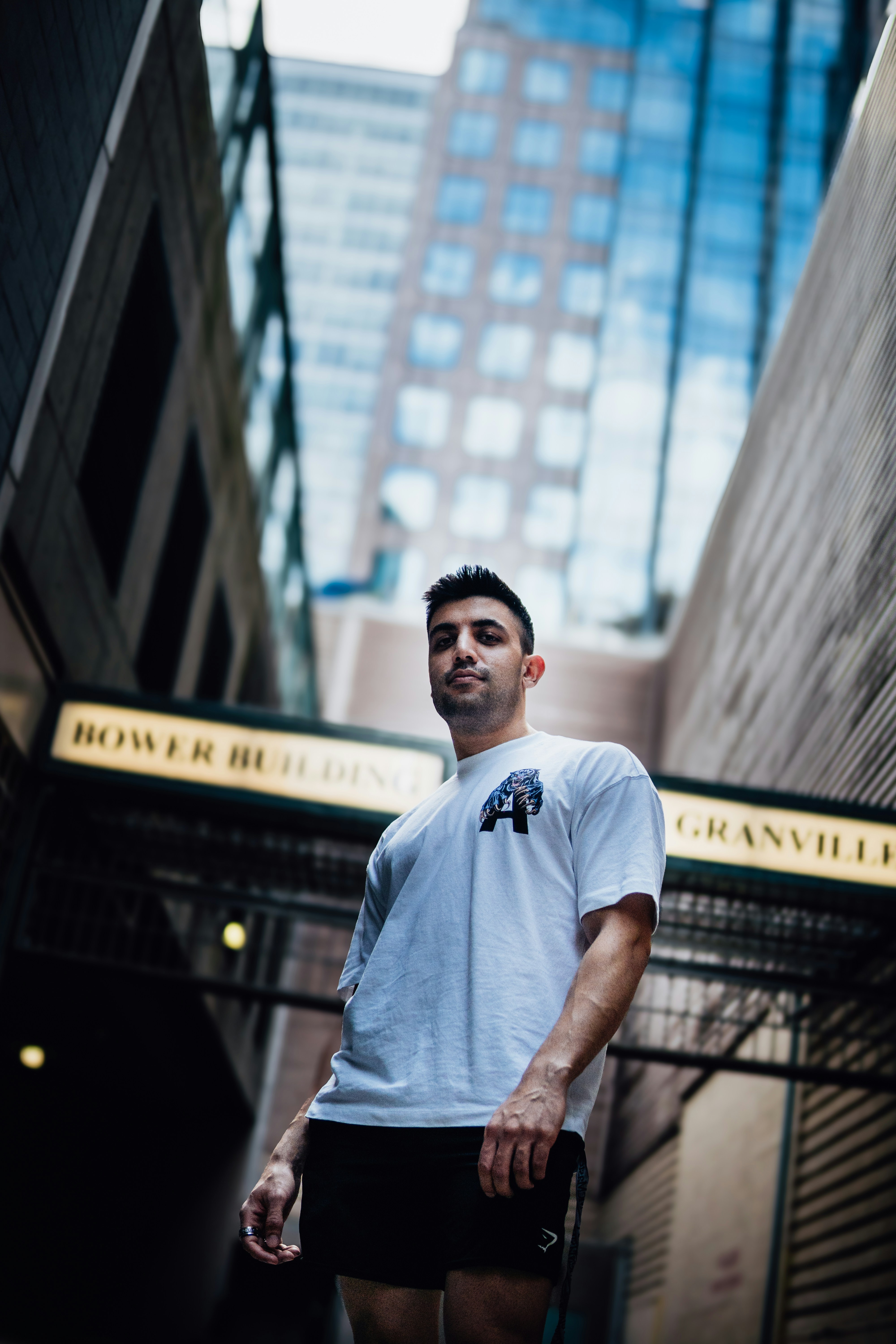 Urban Quiet: A Tall Figure at the Threshold of Glass and Brick