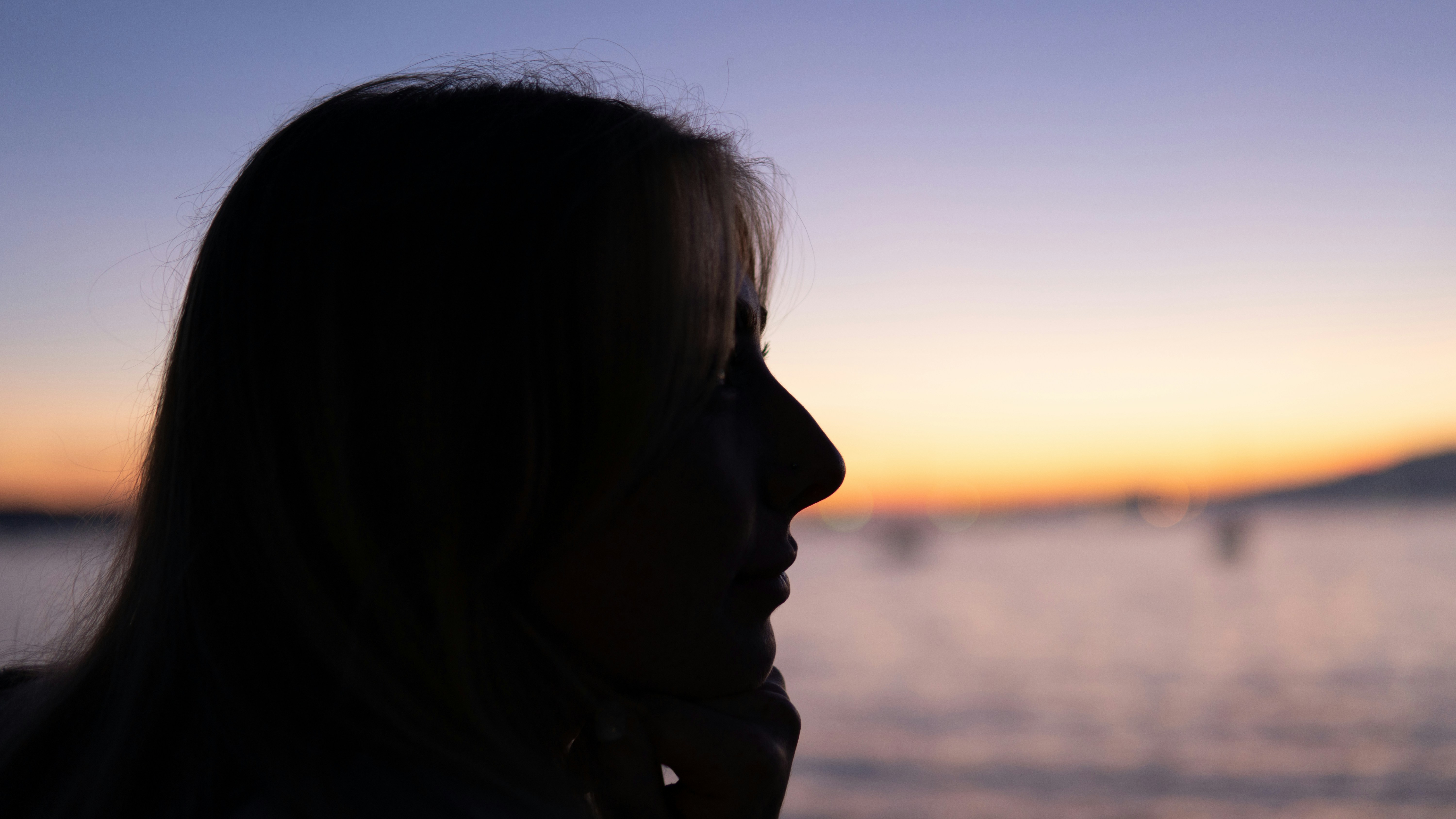 Silhouette at Sunset: A Quiet Profile Over Calm Waters