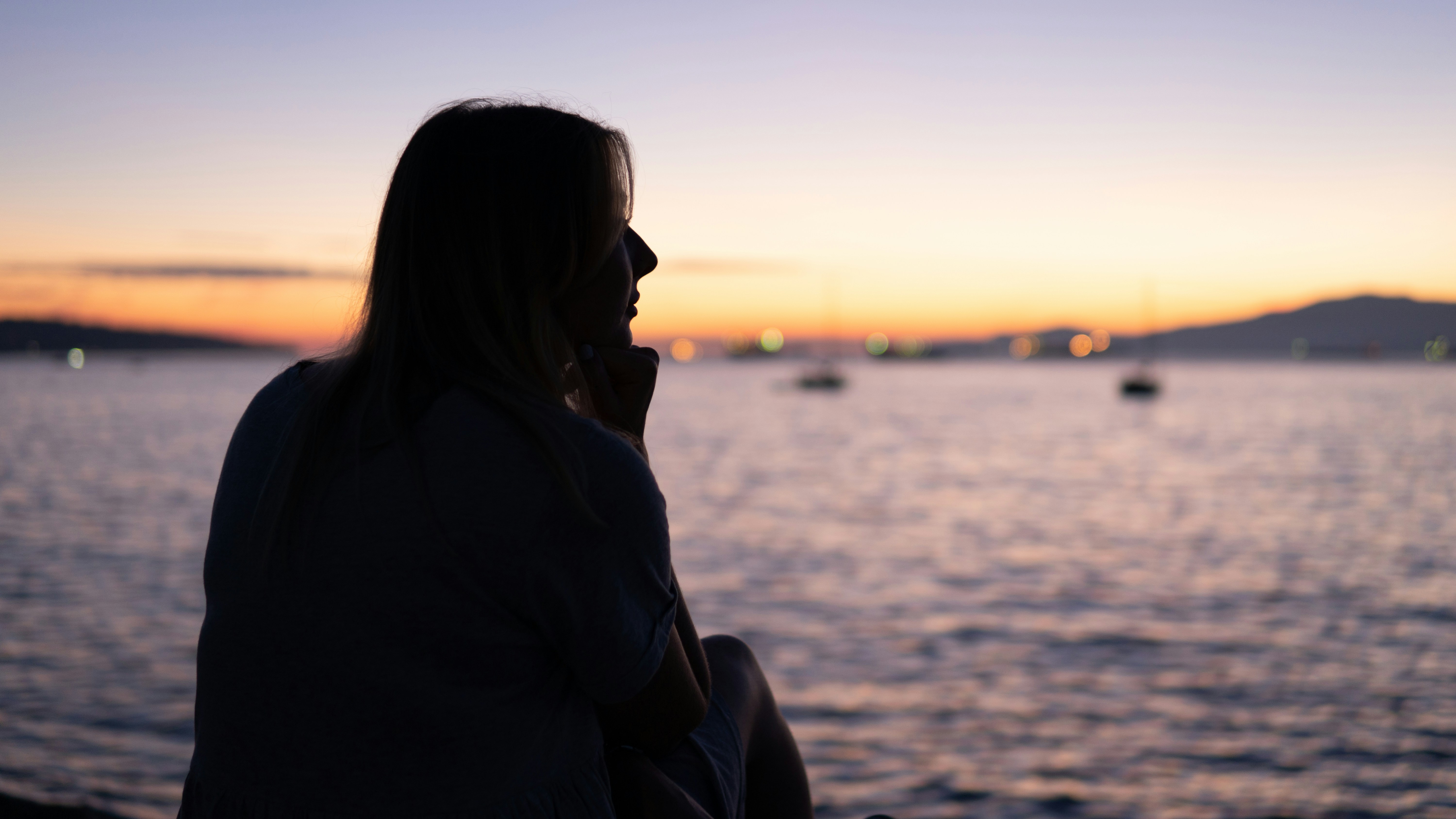 Silhouette at Dusk: A Quiet Moment by the Water