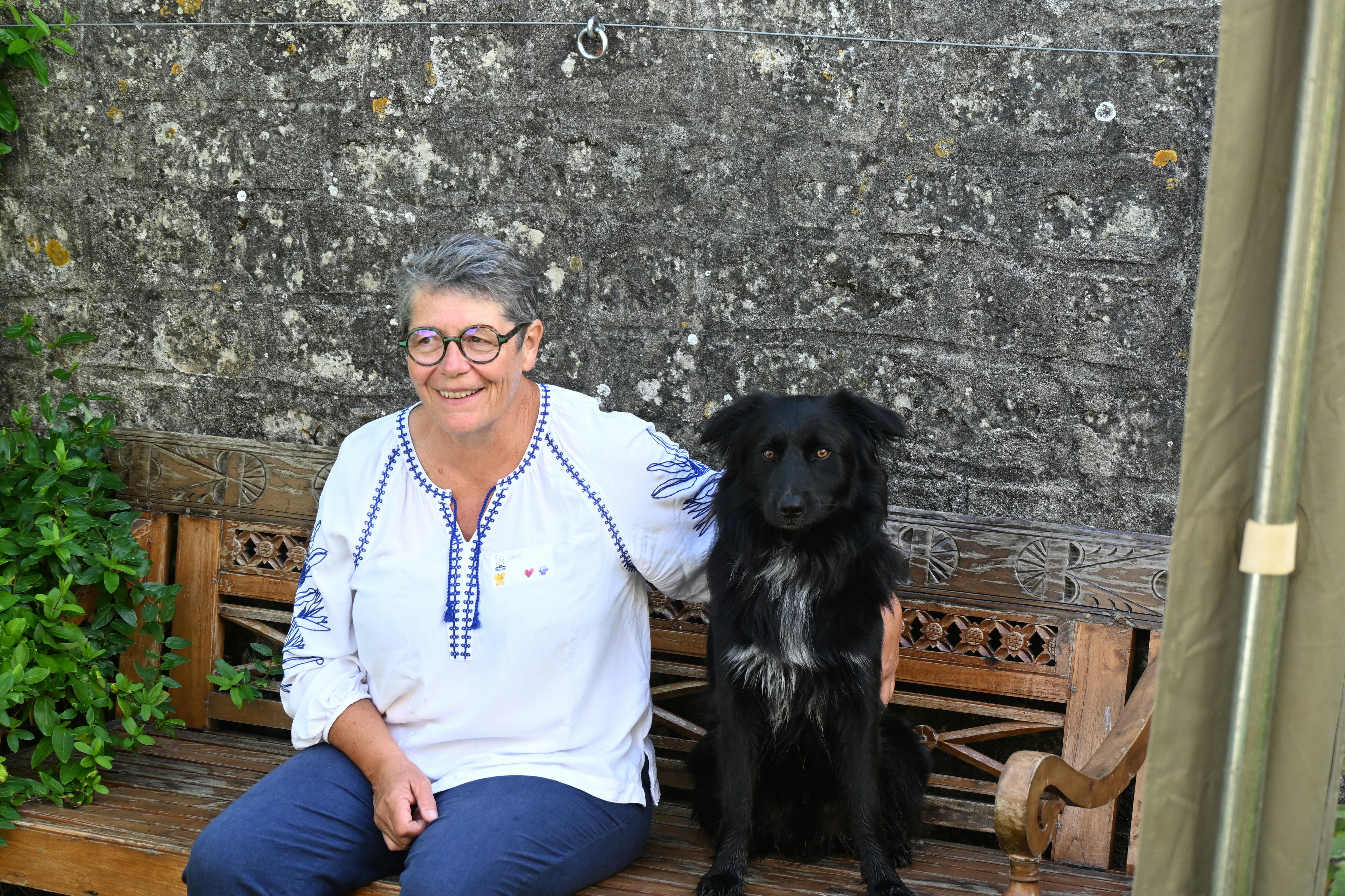 Grandmother and Black Dog on a Bench in Sunlit Garden