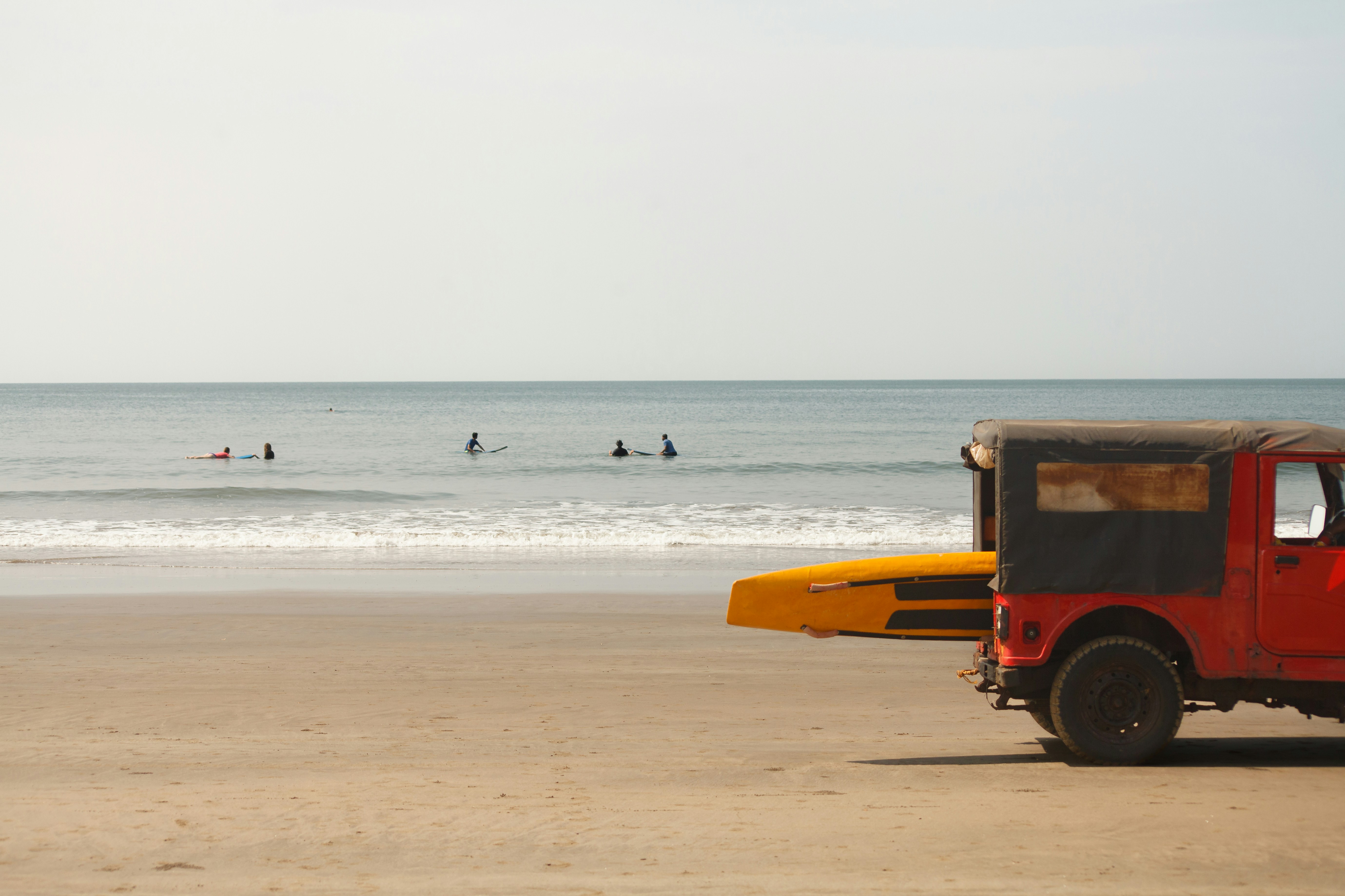 Red Jeep at the Shore: Surfboard in Warm Sand
