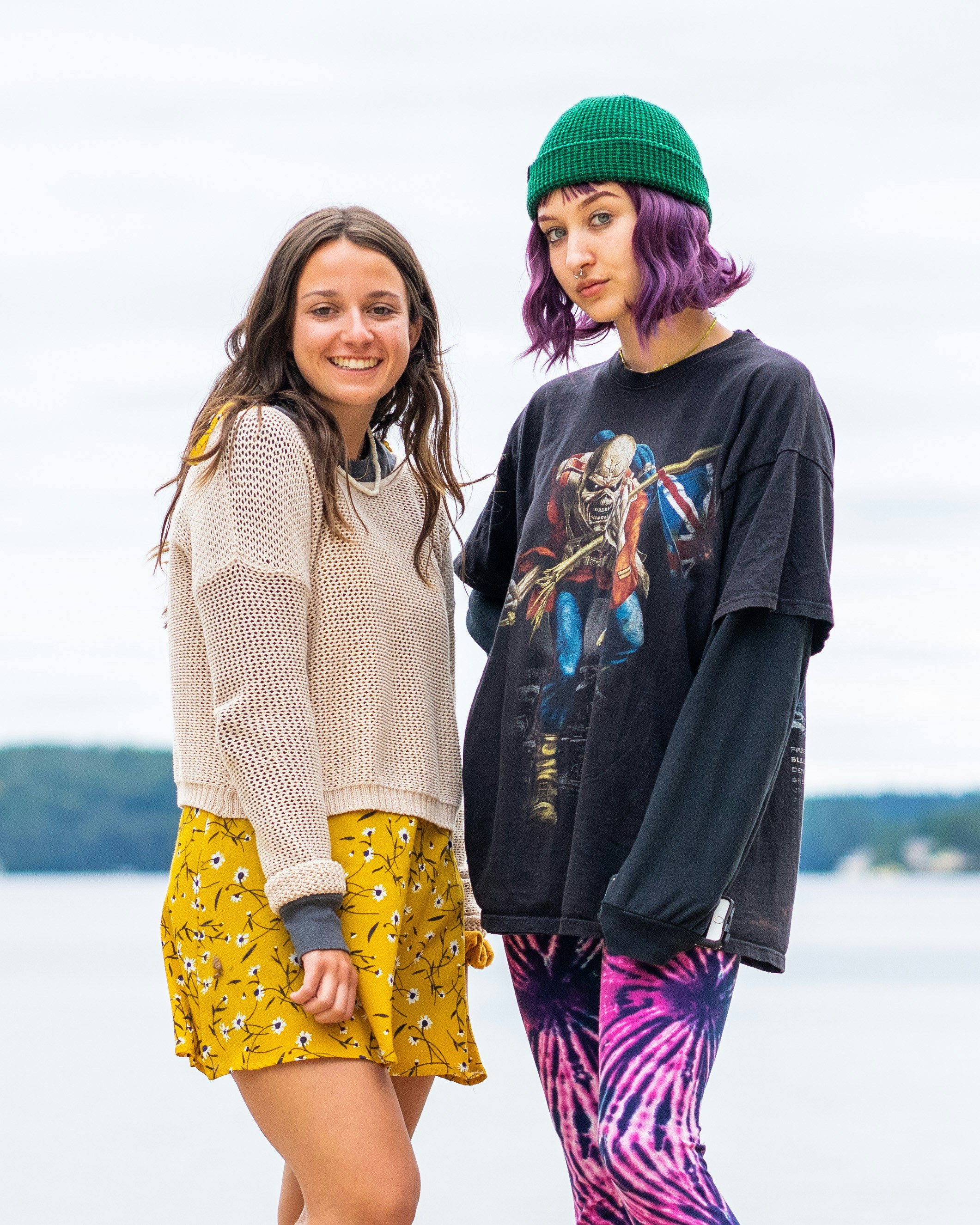 Two friends by the water: neon-green beanie and bold prints