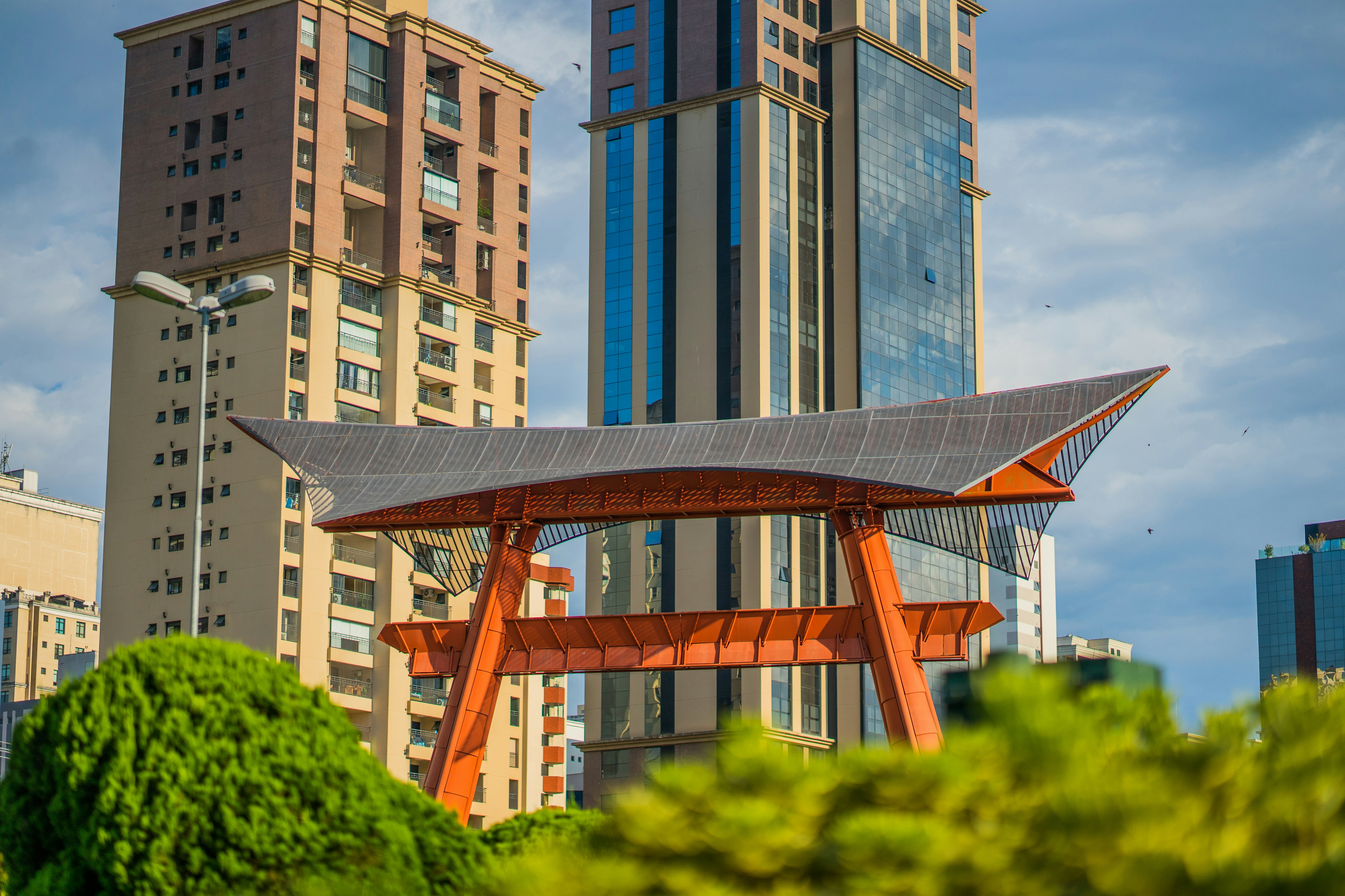 Urban Pylon: Painted Steel Canopy Above the City Garden