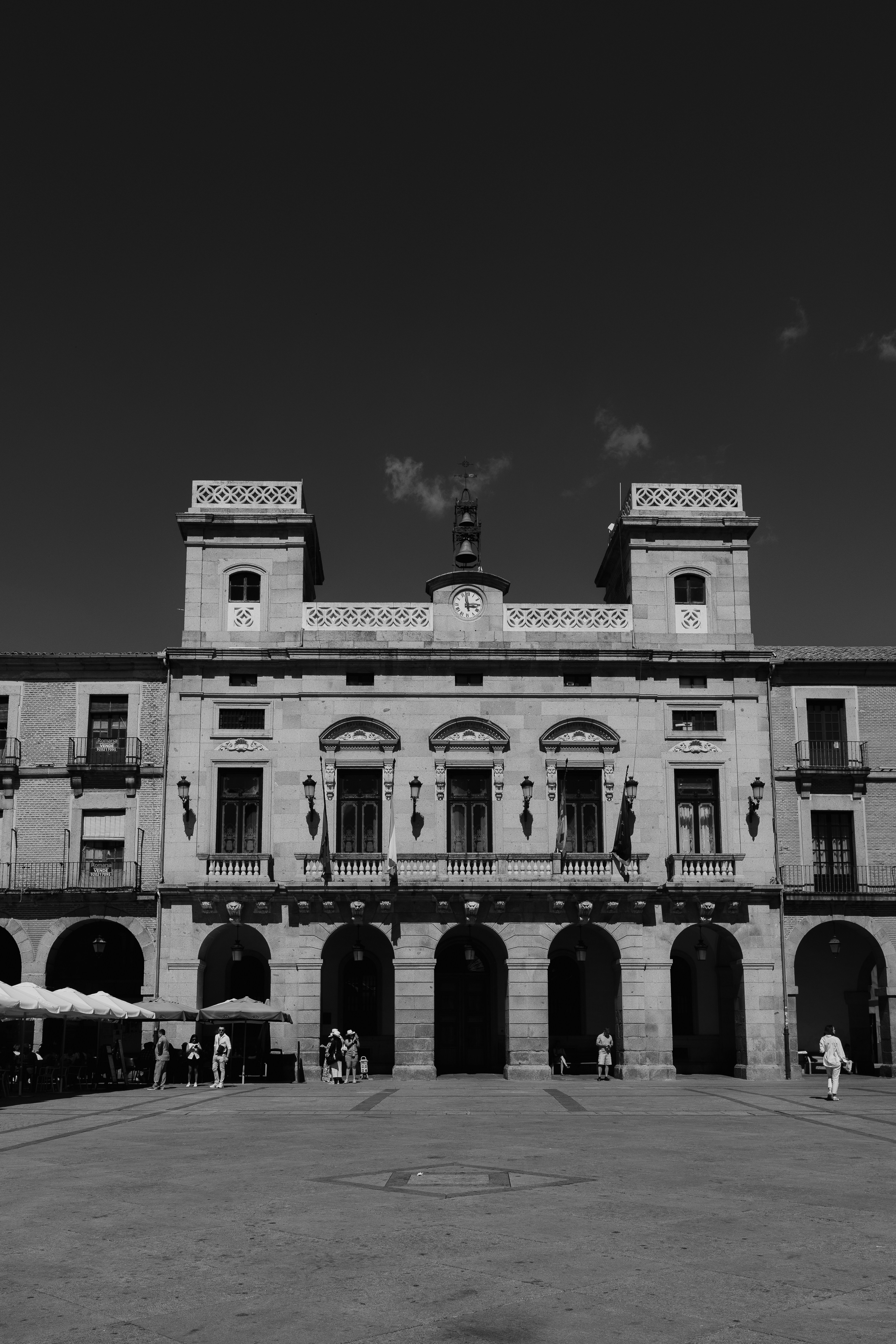 Historic Facades and Shadowed Archways in a Sunlit Plaza