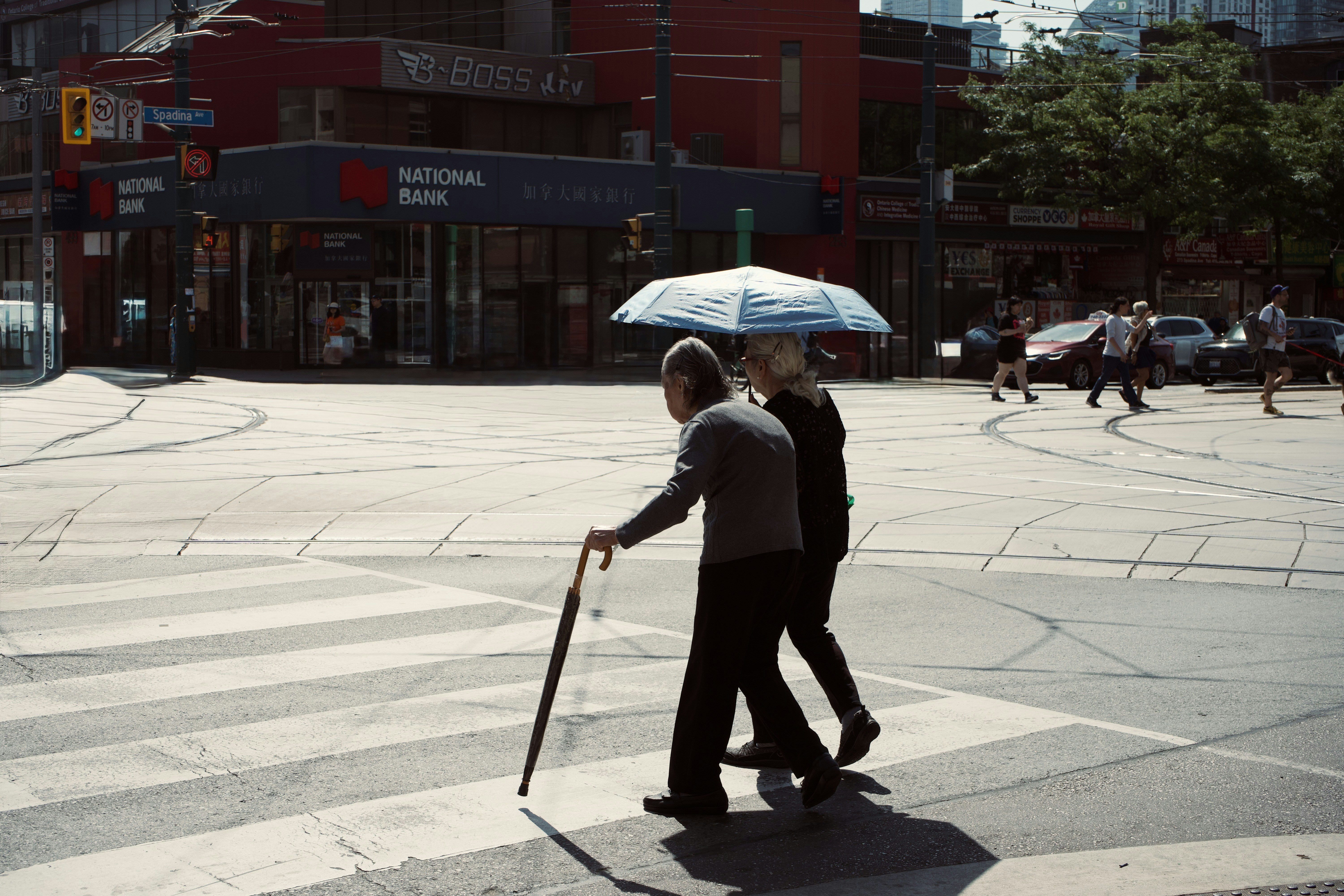Crosswalk Walkers Under an Umbrella in City Square